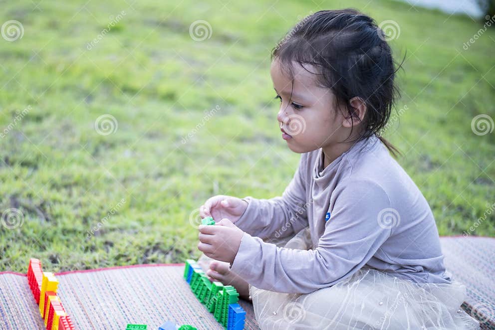 Daughter and Mother Playing with Legos on the Front Yard. Concept of ...
