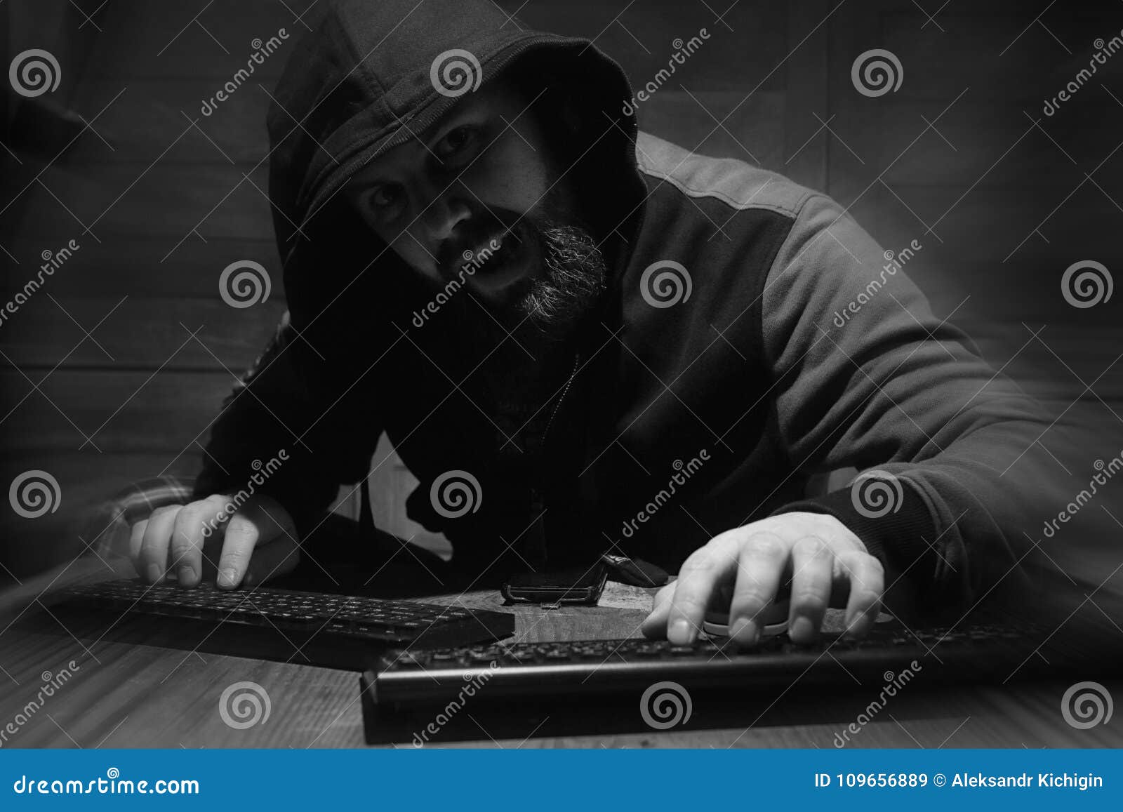 De Hakker in De Kap Zit En Werkt Achter De Computer Stock Afbeelding ...