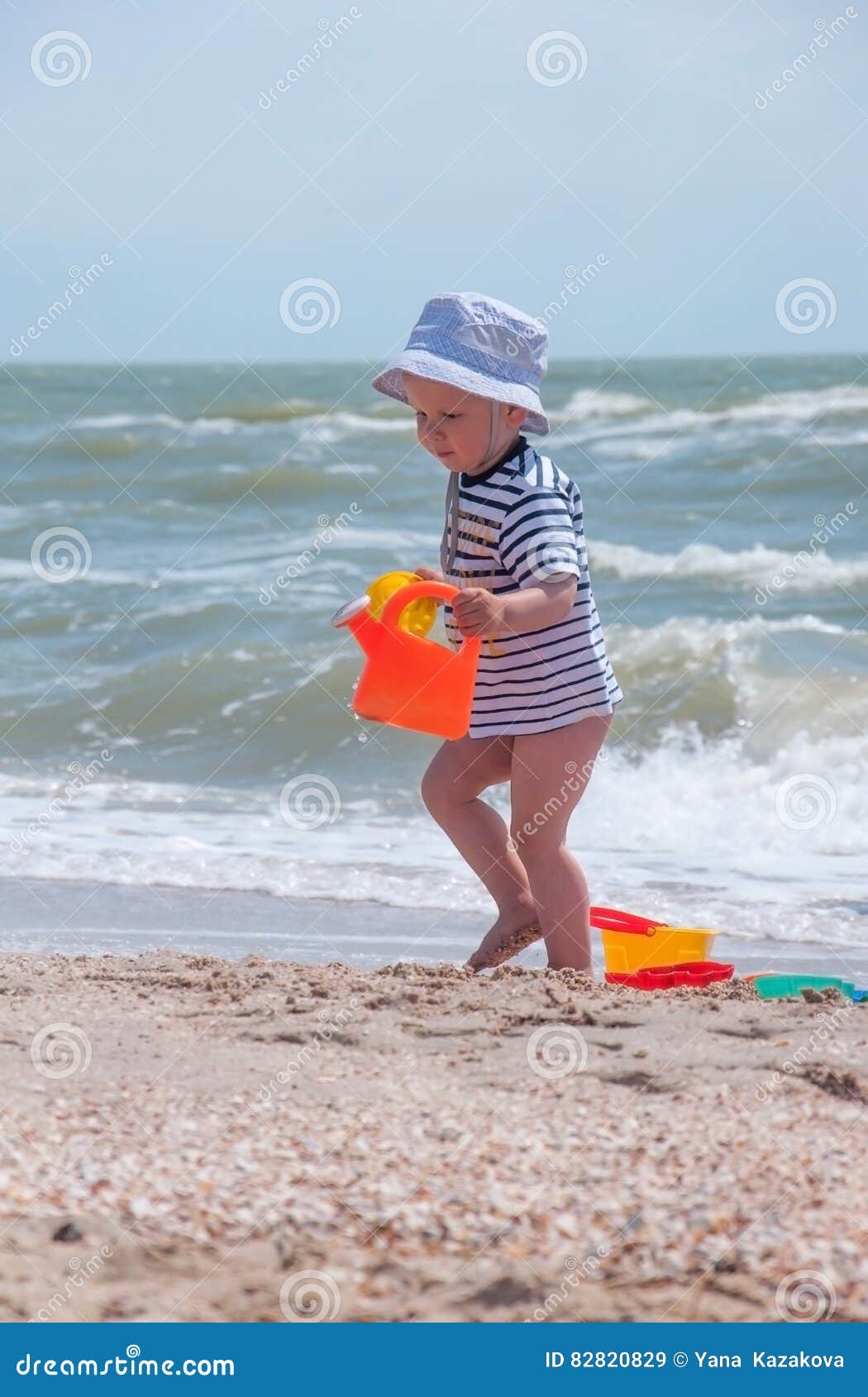 De Leuke Jongen Speelt Een Emmer Op Het Strand Stock Afbeelding - Image ...