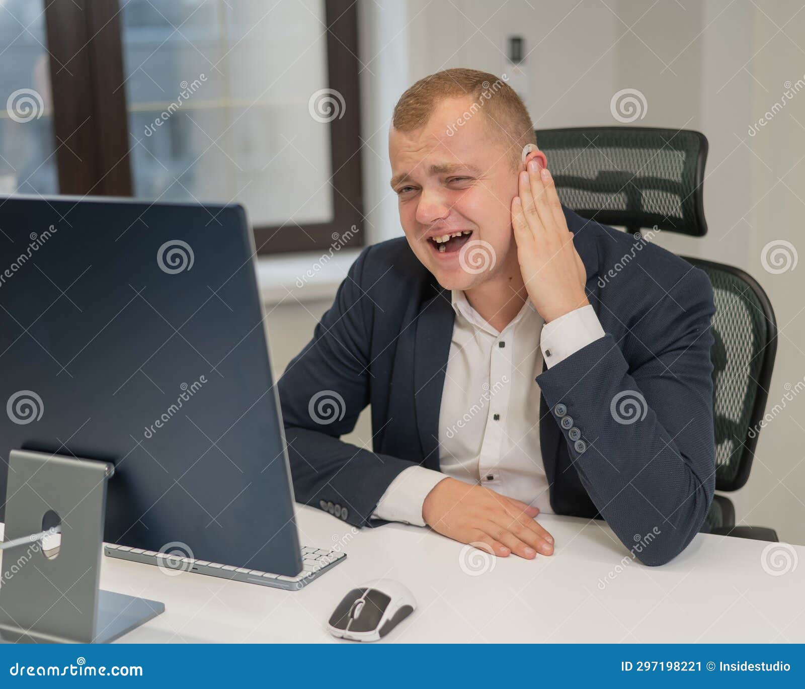 A Deaf Man Works at a Computer in the Office. Broken Hearing Aid ...