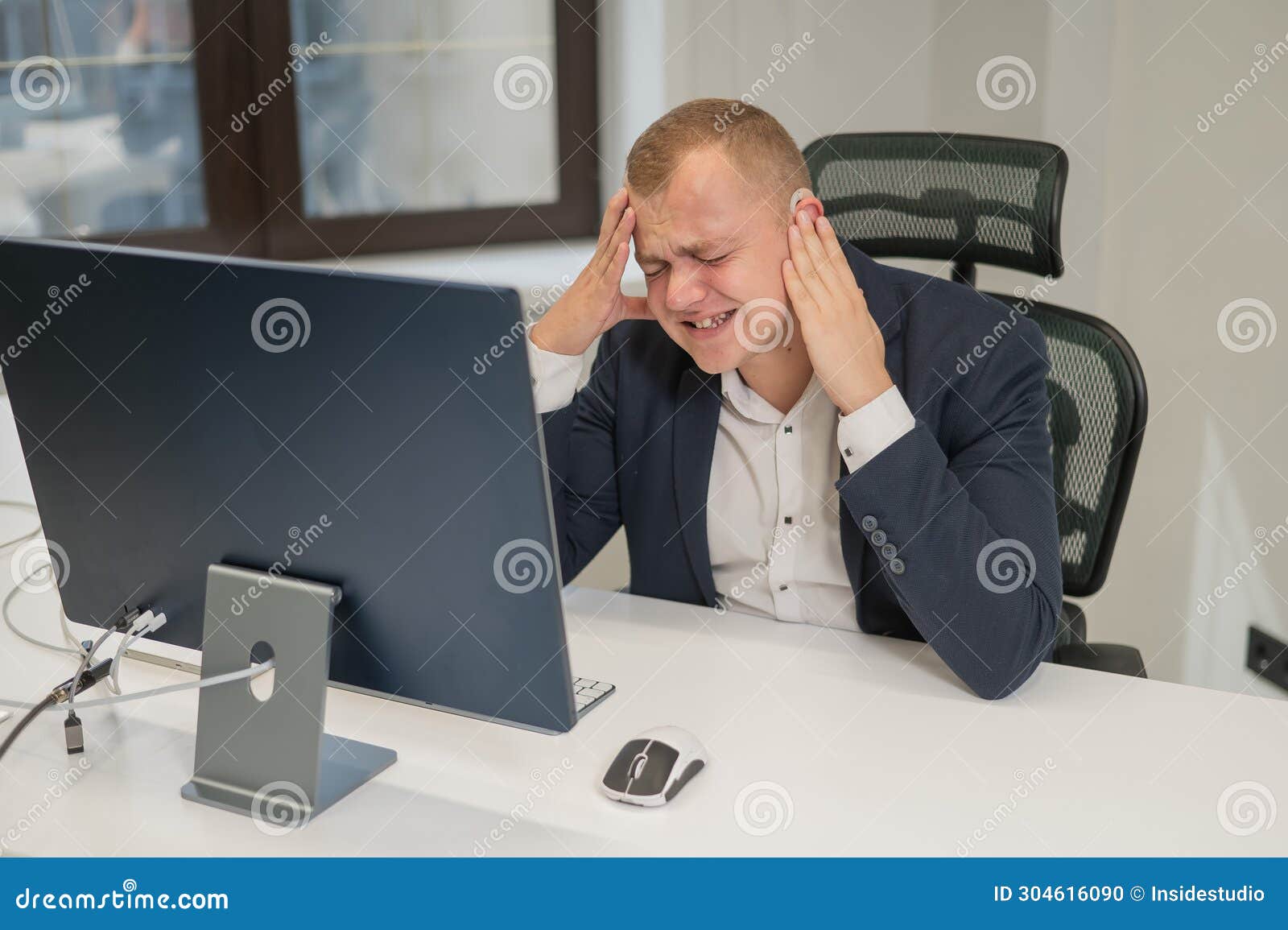 A Deaf Man Works at a Computer in the Office. Broken Hearing Aid ...