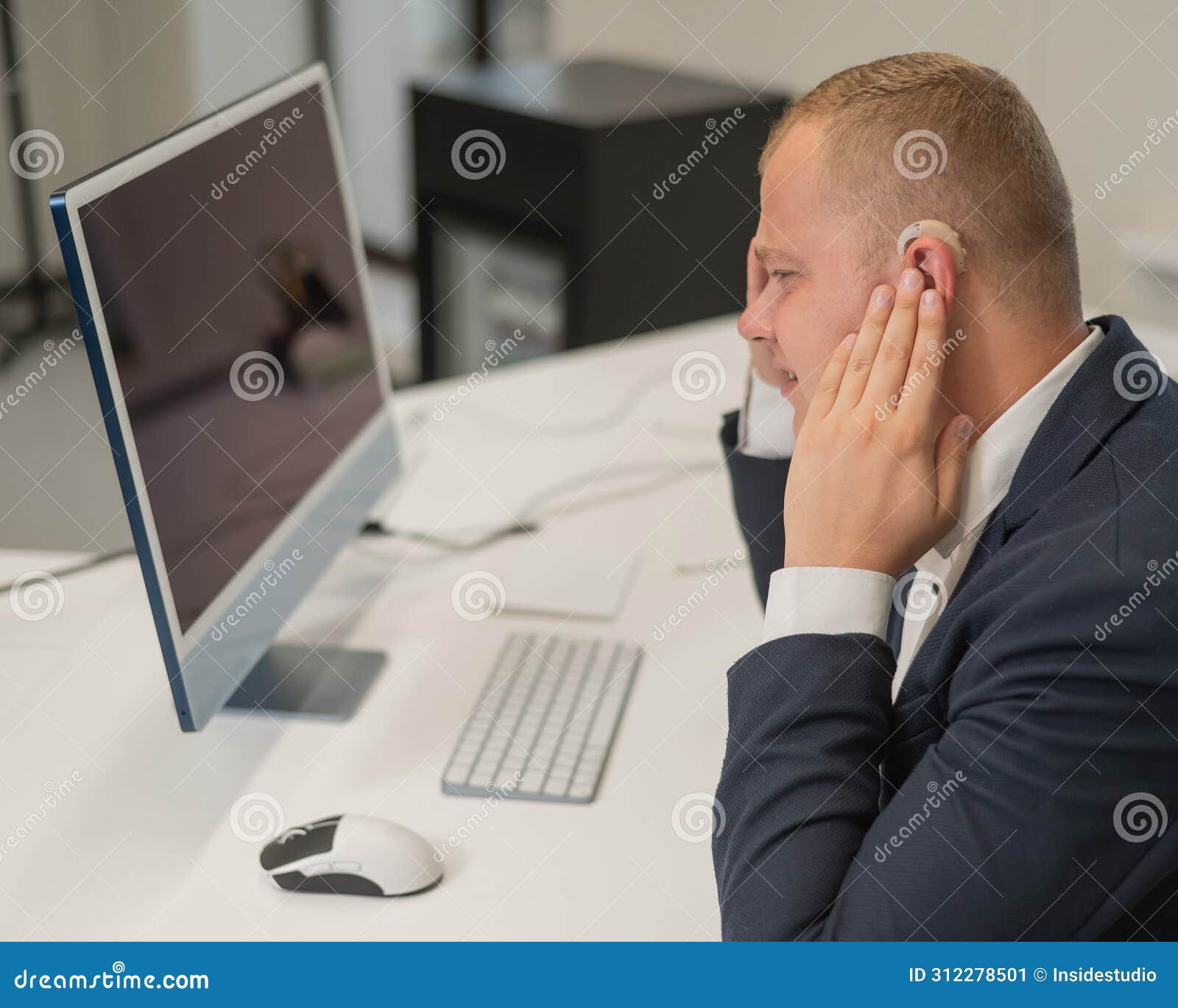 A Deaf Man Works at a Computer in the Office. Broken Hearing Aid ...