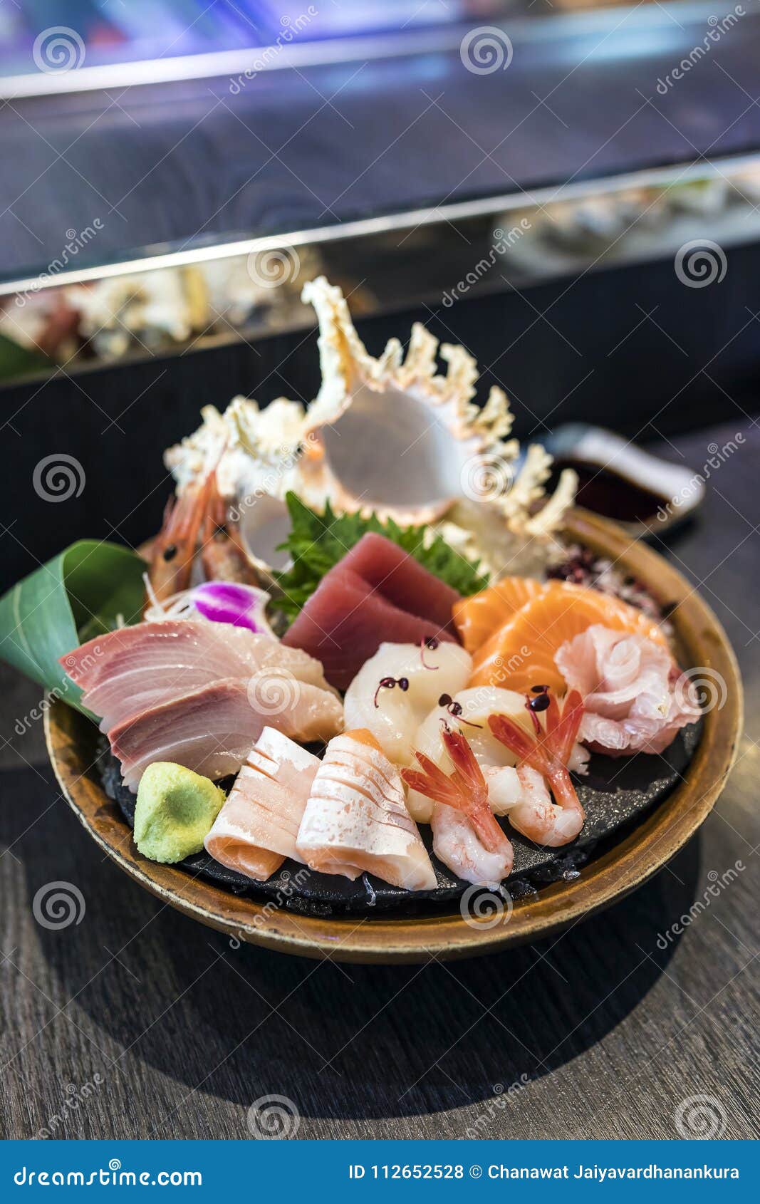 Decorated Sashimi Set in a Bowl with Ice and Conch Shell Near the Chef ...