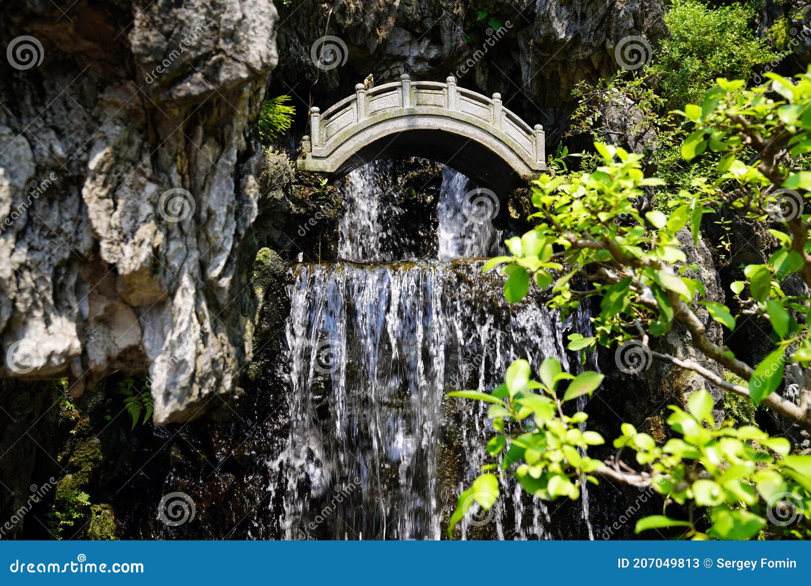 Decorative Fountain with a Bridge between Rocks in the Park Stock Image ...