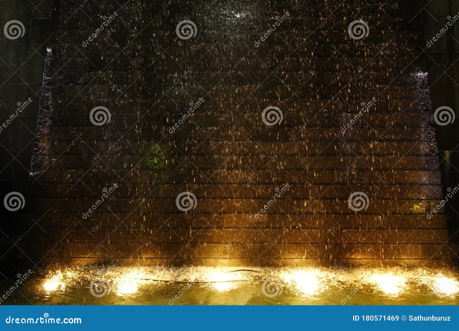Decorative Waterfall with Yellow Light Lighting Up from Under the Water ...