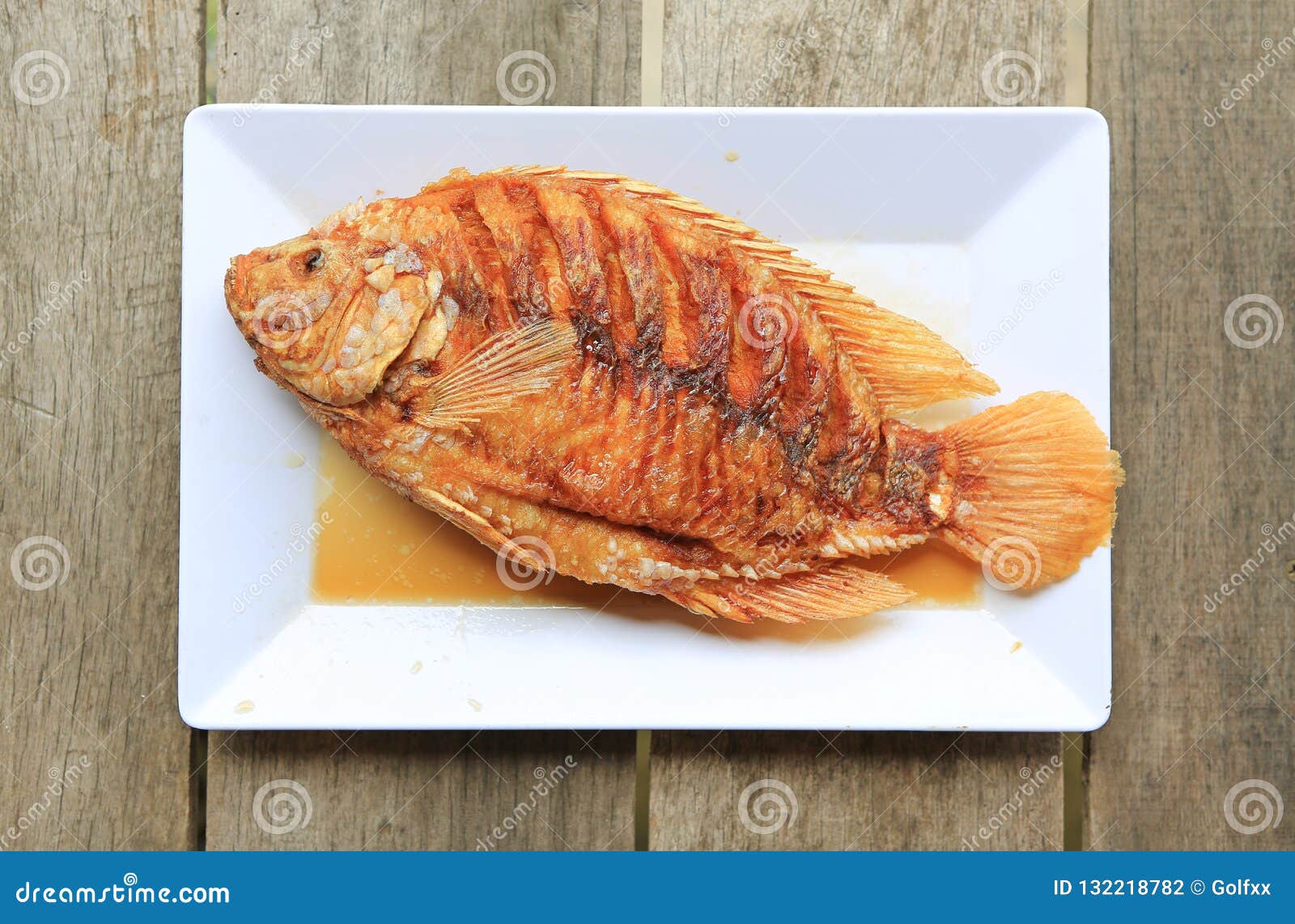 Deep Fried Ruby Fish on White Square Plate Against Wooden Table ...