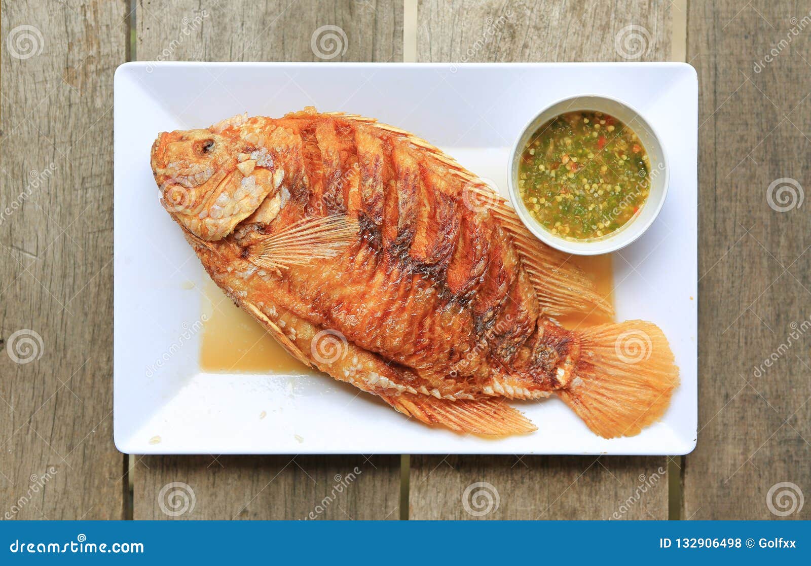 Deep Fried Ruby Fish on White Square Plate with Spicy Sauce Against ...