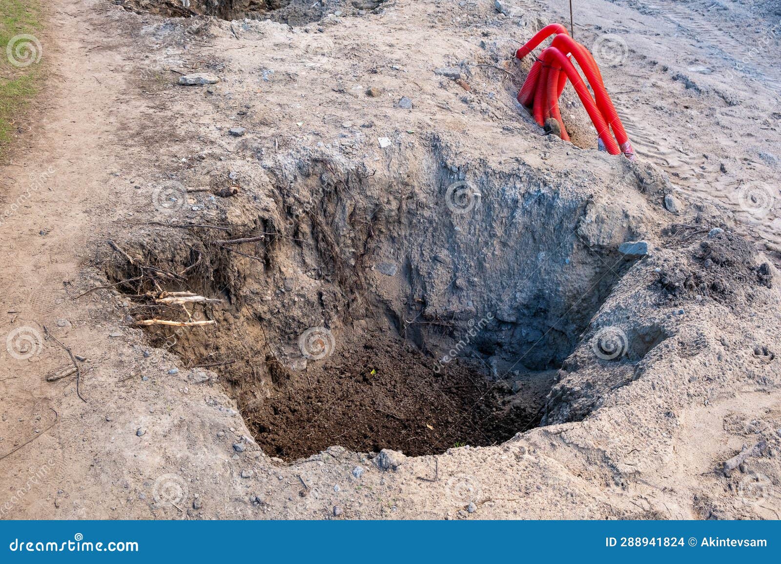 Deep Pit at the Construction Site and Cables in Red Flexible Pipes ...