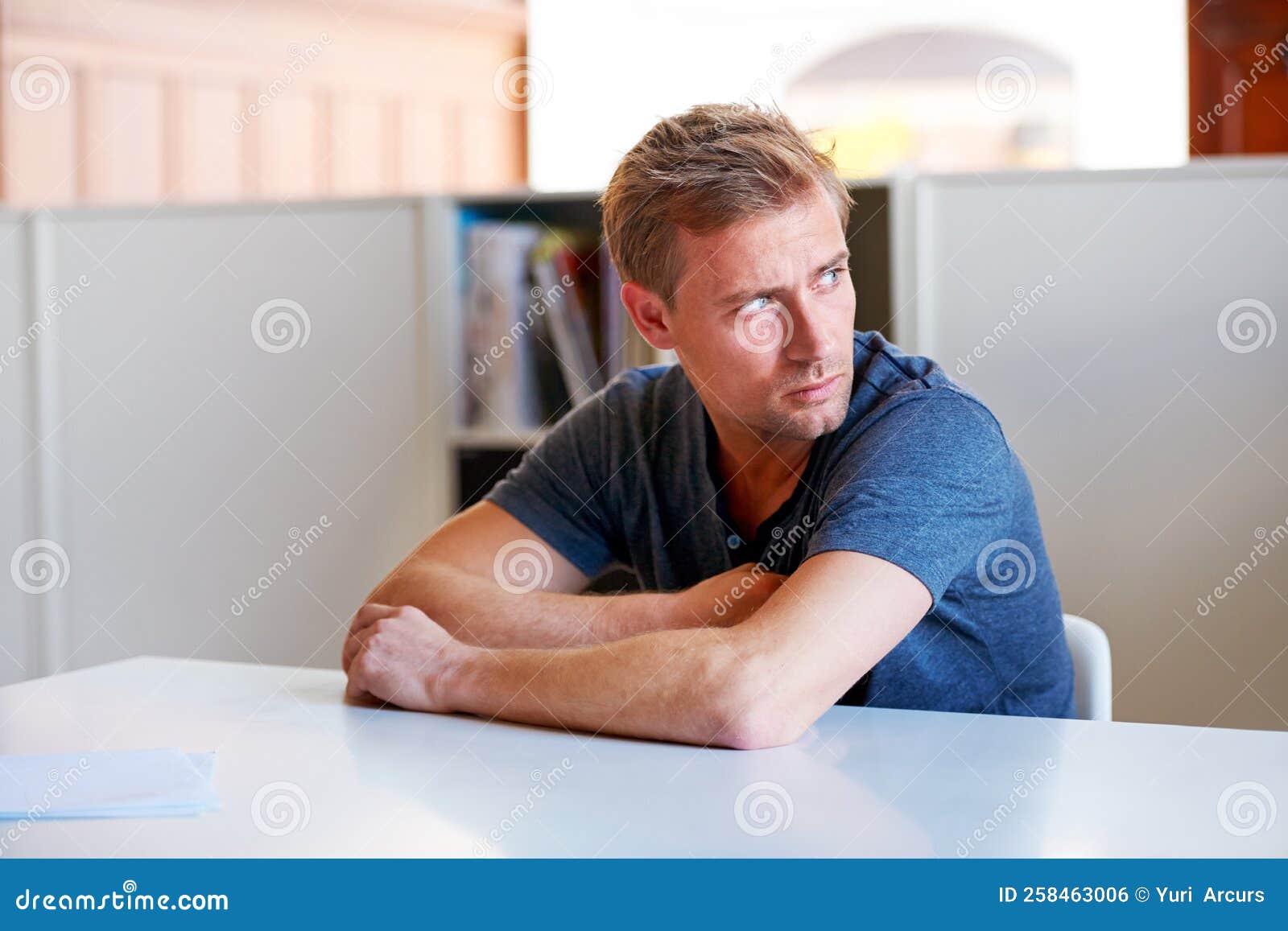 Deep in Thought. a Young Man Sitting at a Table Looking Off To the Side ...