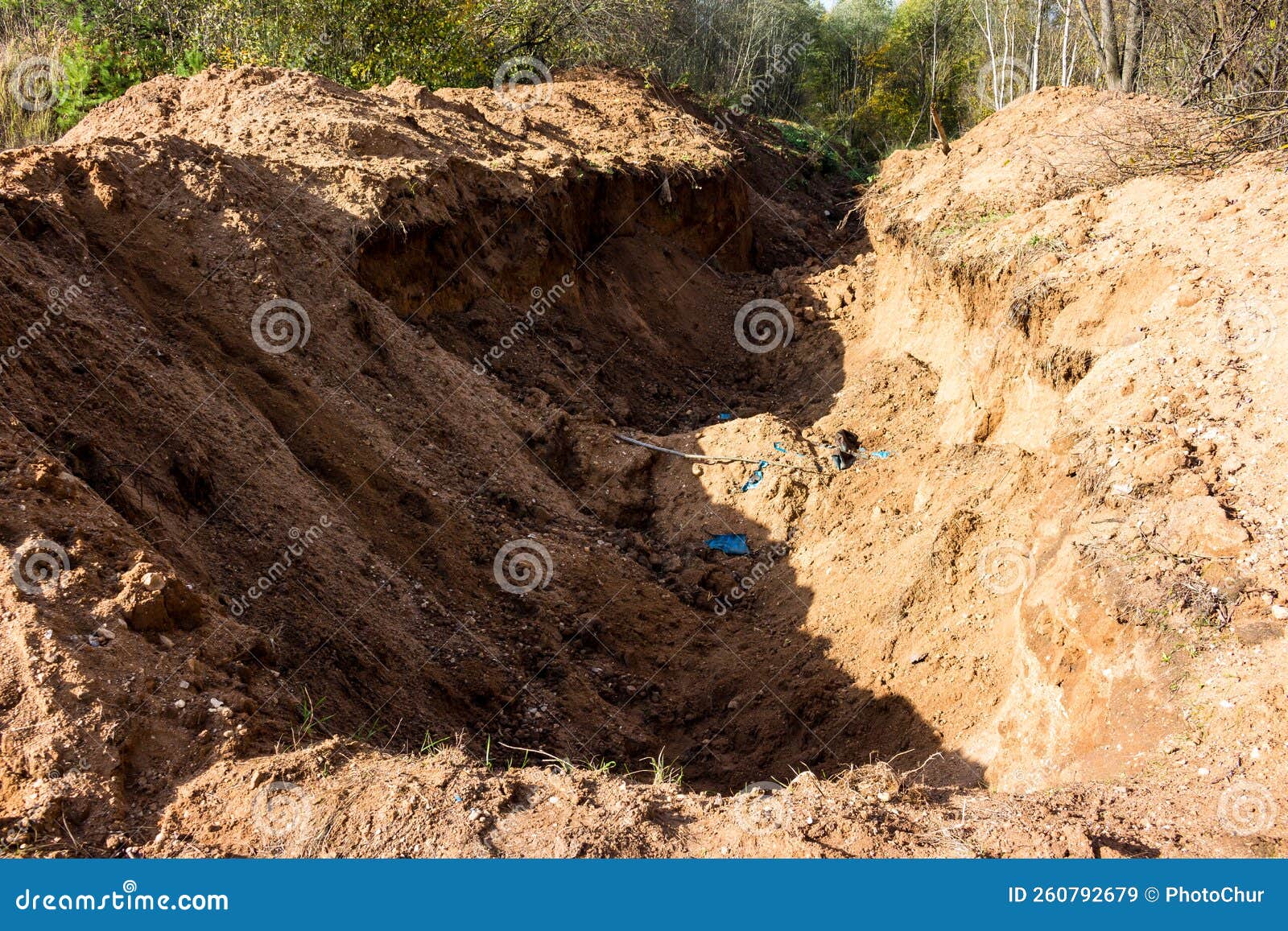 A Deep Trench Dug in Sandy Soil in a Forest Area for Laying Engineering ...