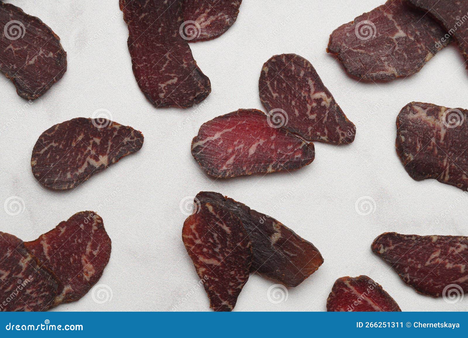 Delicious Beef Jerky on White Table, Flat Lay Stock Image - Image of ...
