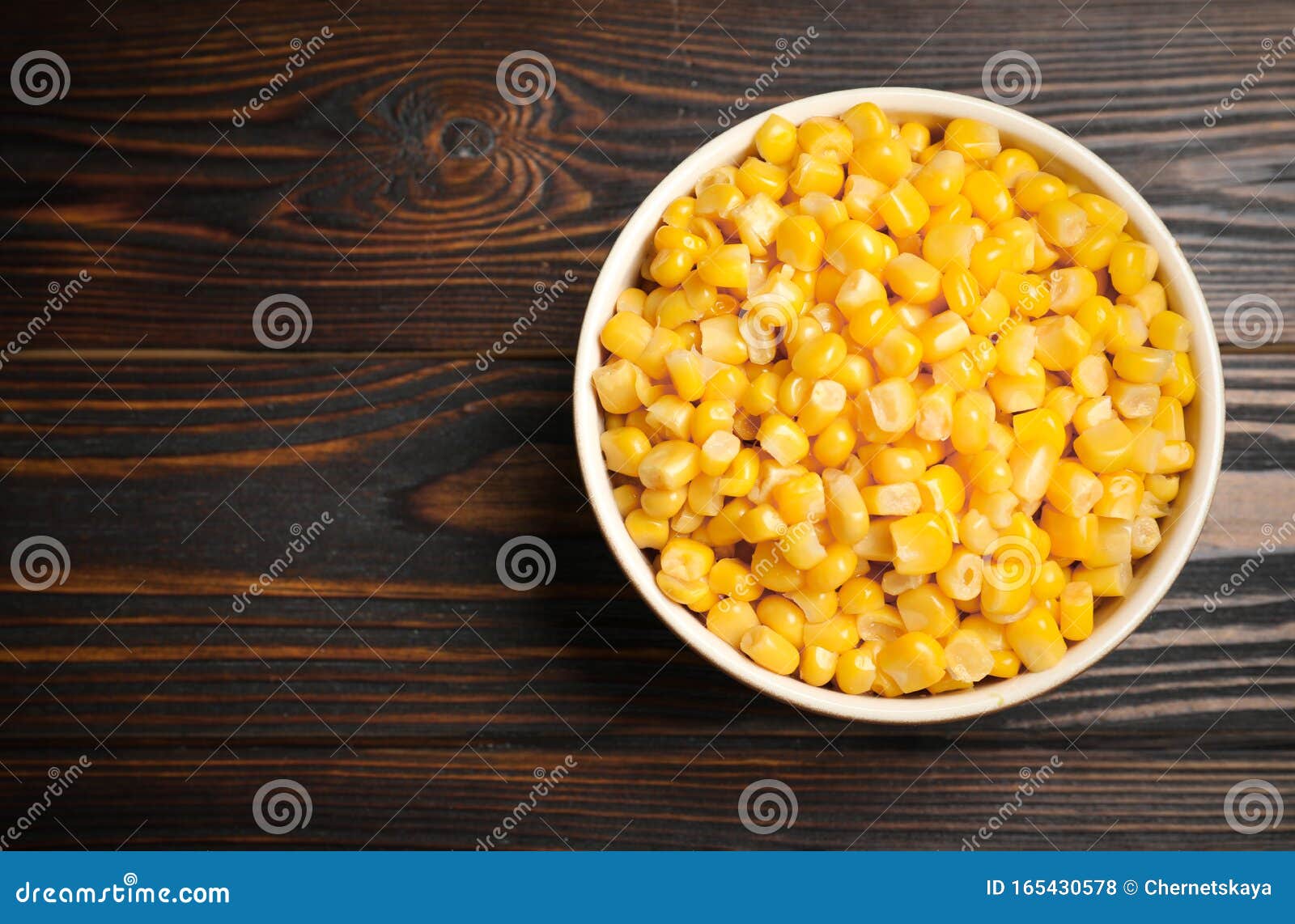 Delicious Canned Corn in Bowl on Wooden Table, Top View. Space for Text ...