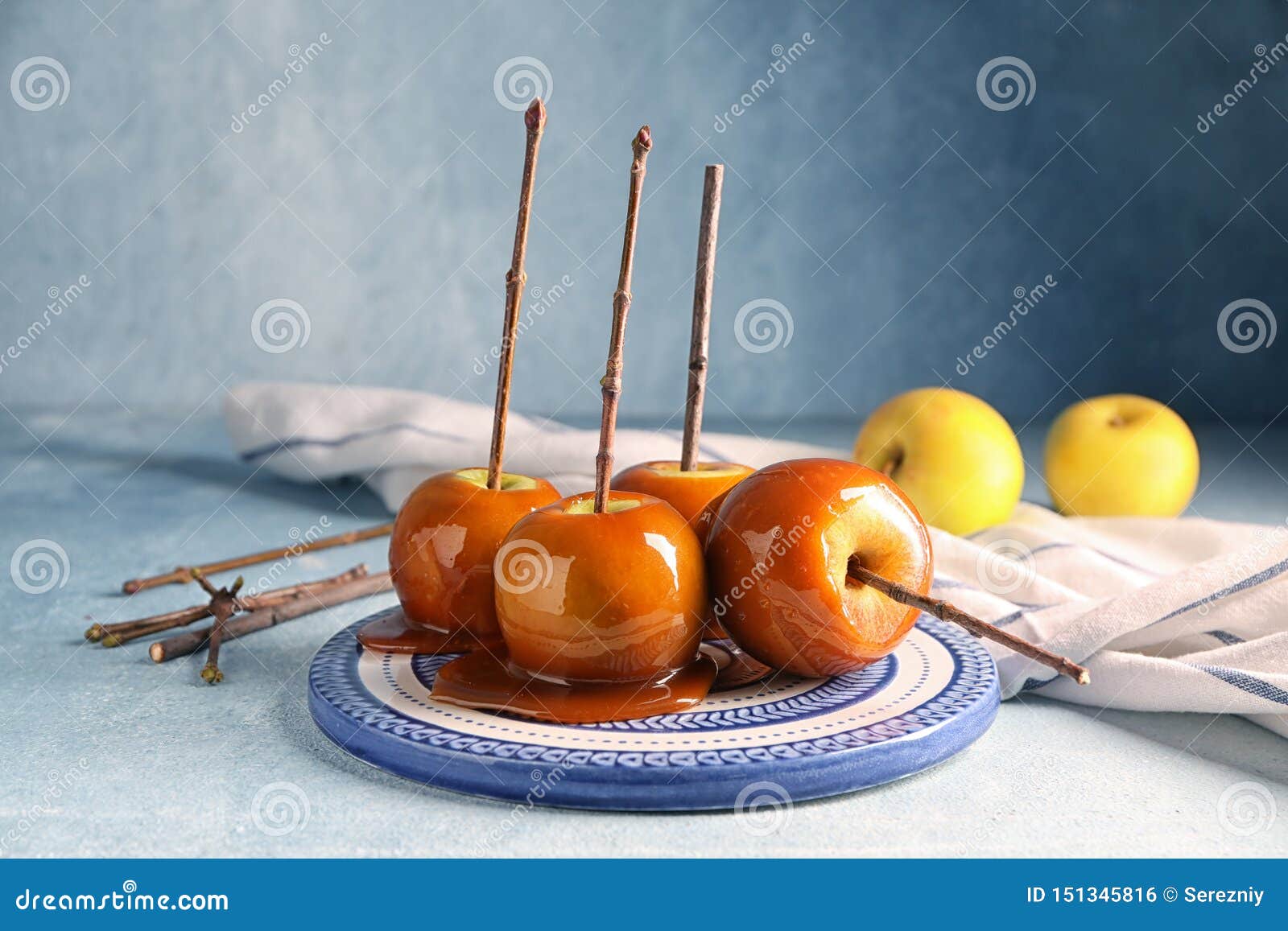 Delicious Caramel Apples with Tree Branches on Plate Stock Photo ...