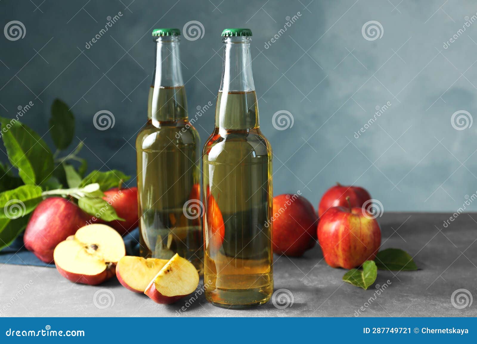 Delicious Cider and Apples with Green Leaves on Gray Table Stock Image ...