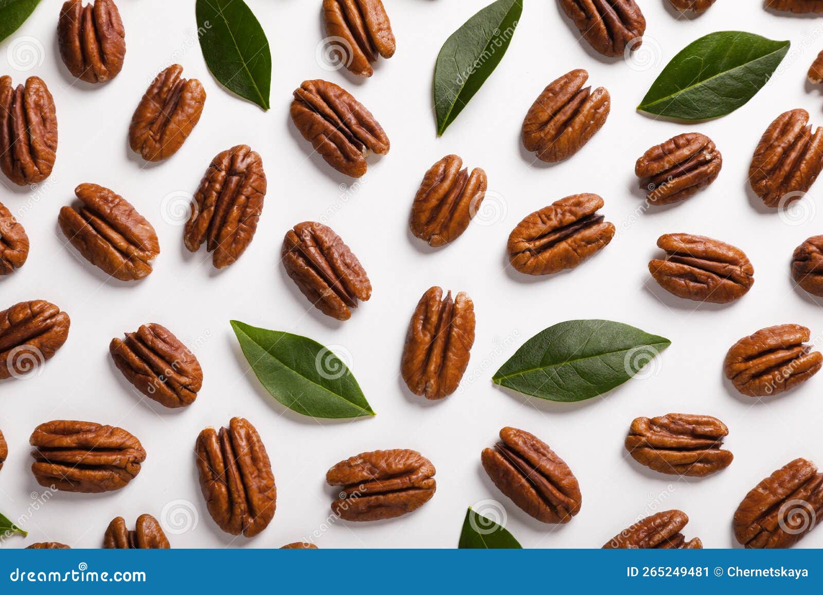Delicious Pecan Nuts and Green Leaves on White Background, Flat Lay ...
