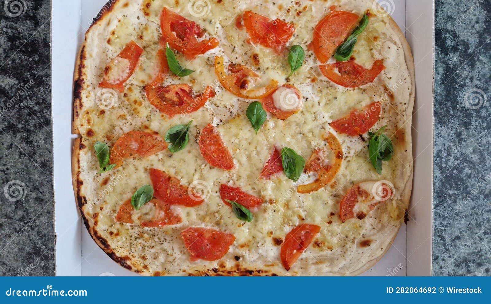 Delicious Pizza in a Box Presented on a Table, with Tomatoes and Cheese ...