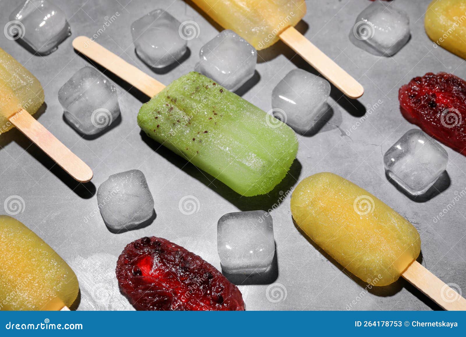 Delicious Pops and Ice Cubes on Grey Table. Fruit Popsicle Stock Image ...