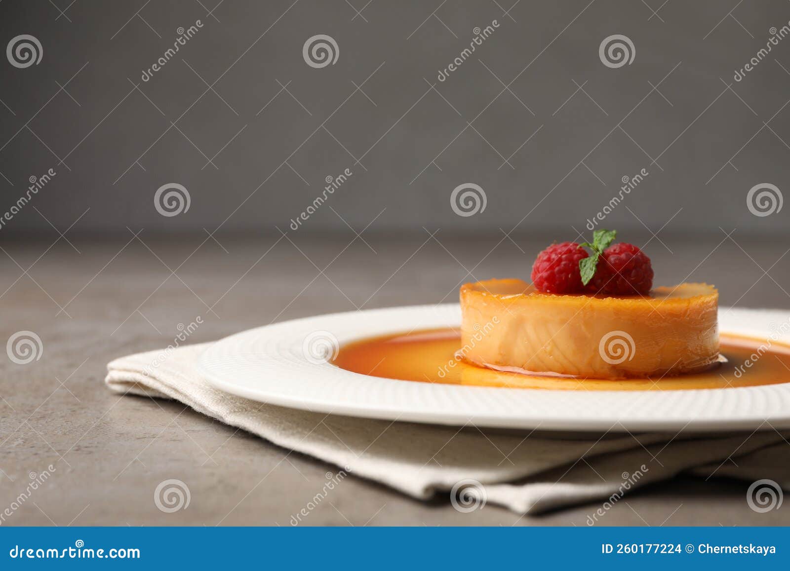 Delicious Pudding with Caramel and Raspberries on Grey Table. Space for ...