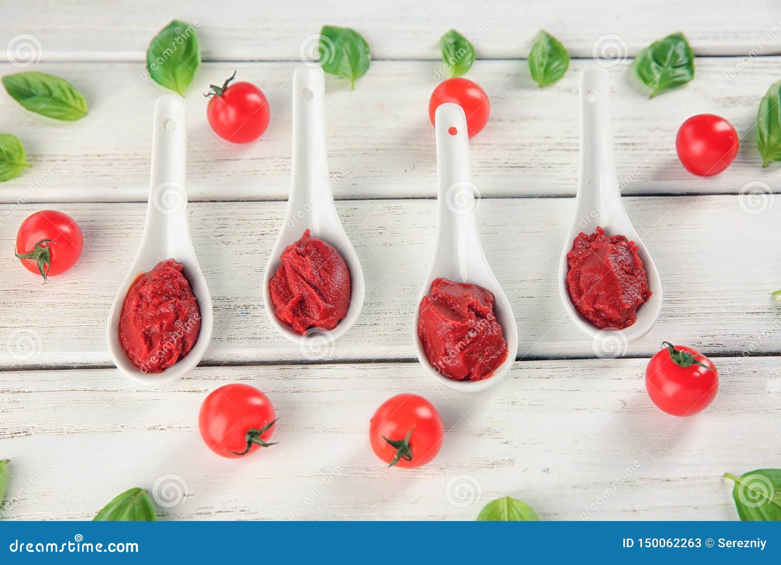 Delicious Red Sauce in Ceramic Spoons with Cherry Tomatoes on Table ...