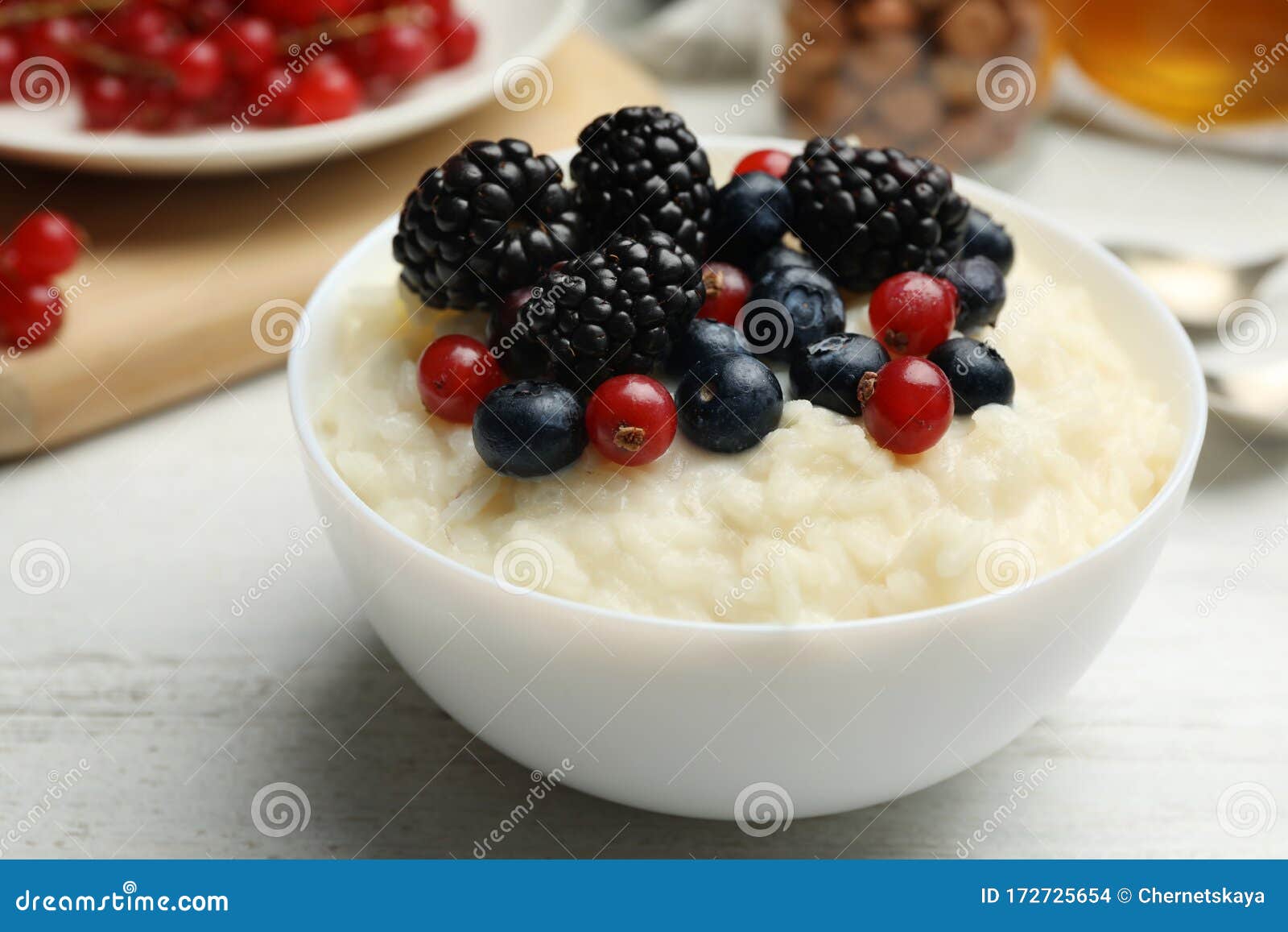 Delicious Rice Pudding with Berries on Wooden Table, Closeup Stock ...