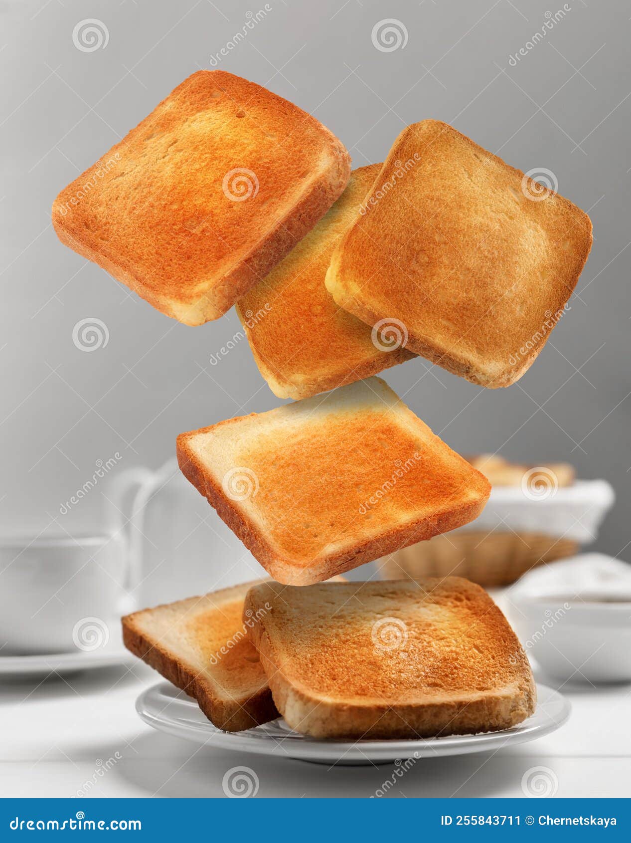 Delicious Toasted Bread Falling into Plate on White Table Stock Image ...