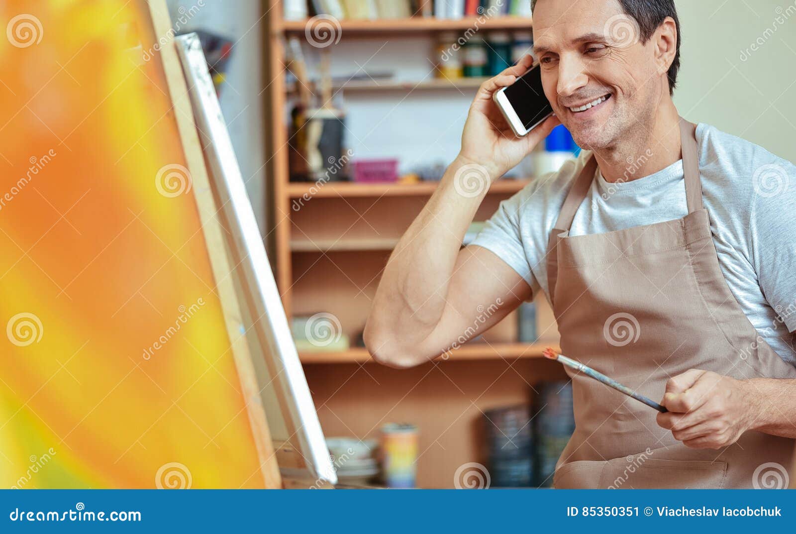 Delighted Artist Using Cellphone in Painting Studio Stock Image - Image ...