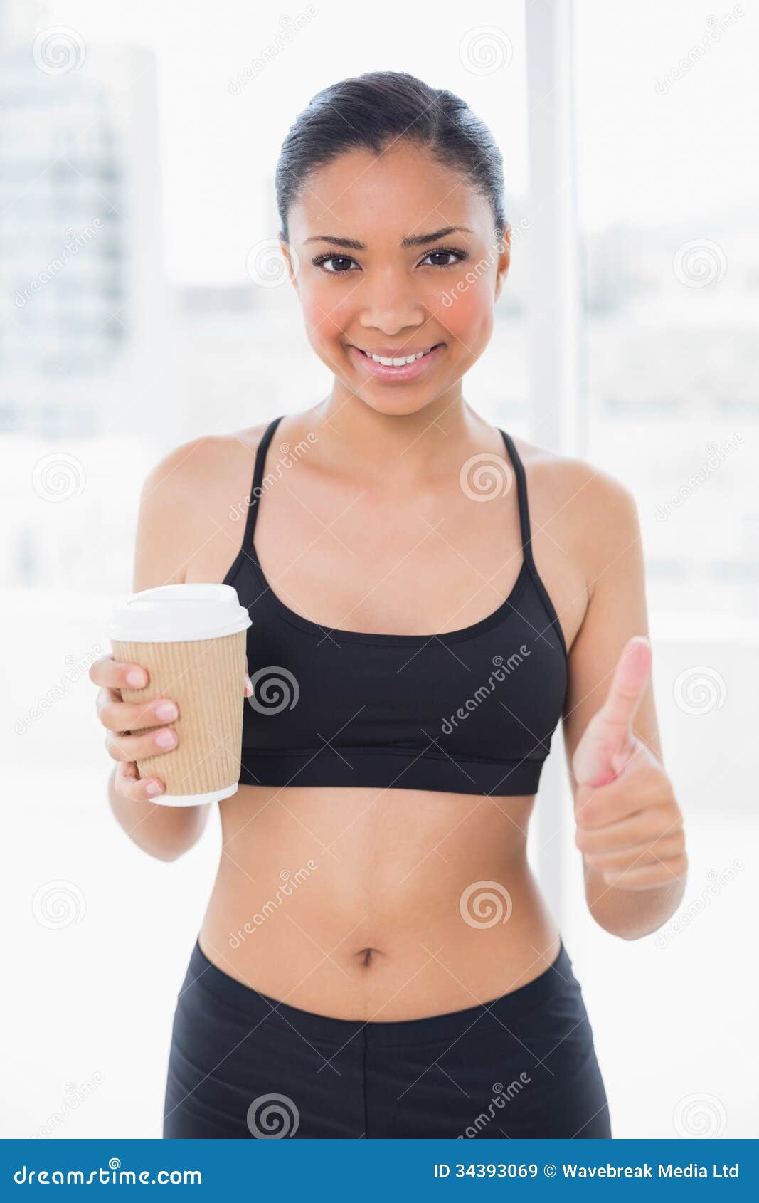Delighted Dark Haired Model In Sportswear Holding Cup Of Coffee And