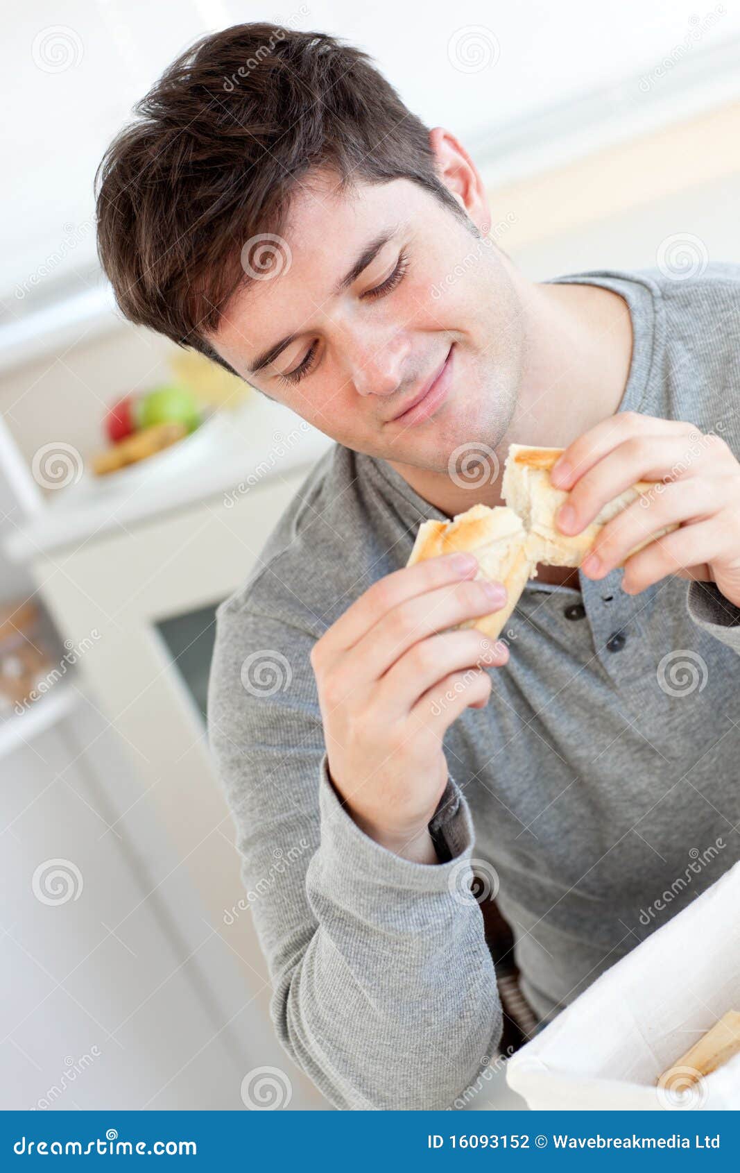 Delighted Man Eating Bread in the Kitchen Stock Photo - Image of ...