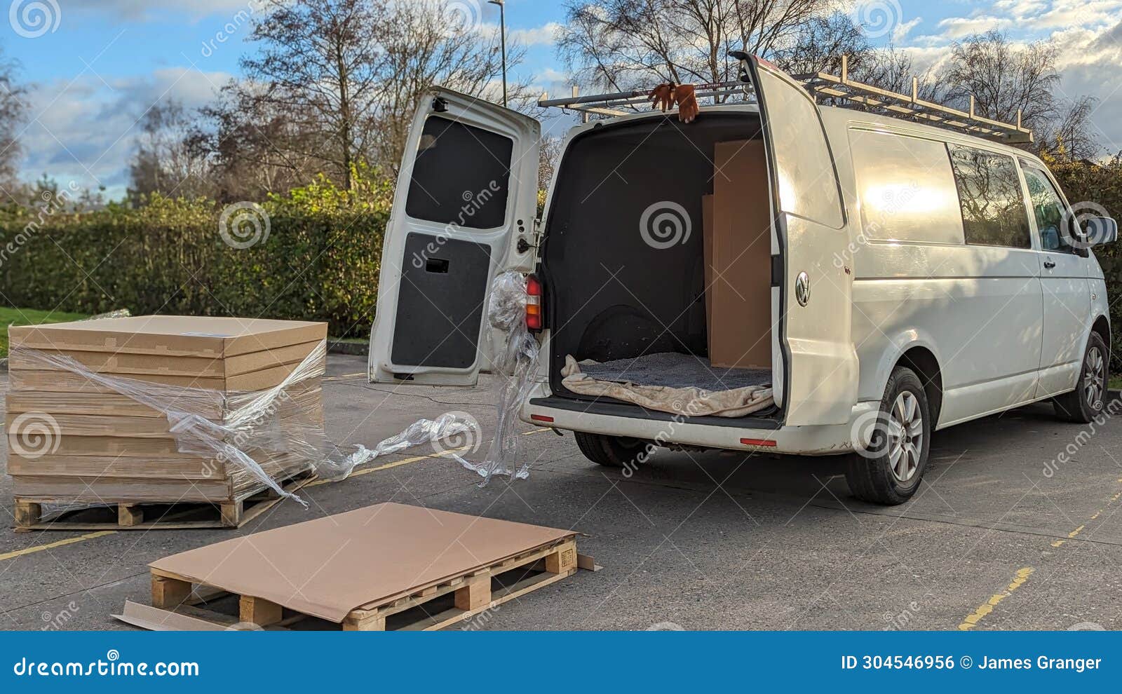 Delivering and Unloading Pallets of Boxes Out of a White Van Stock ...