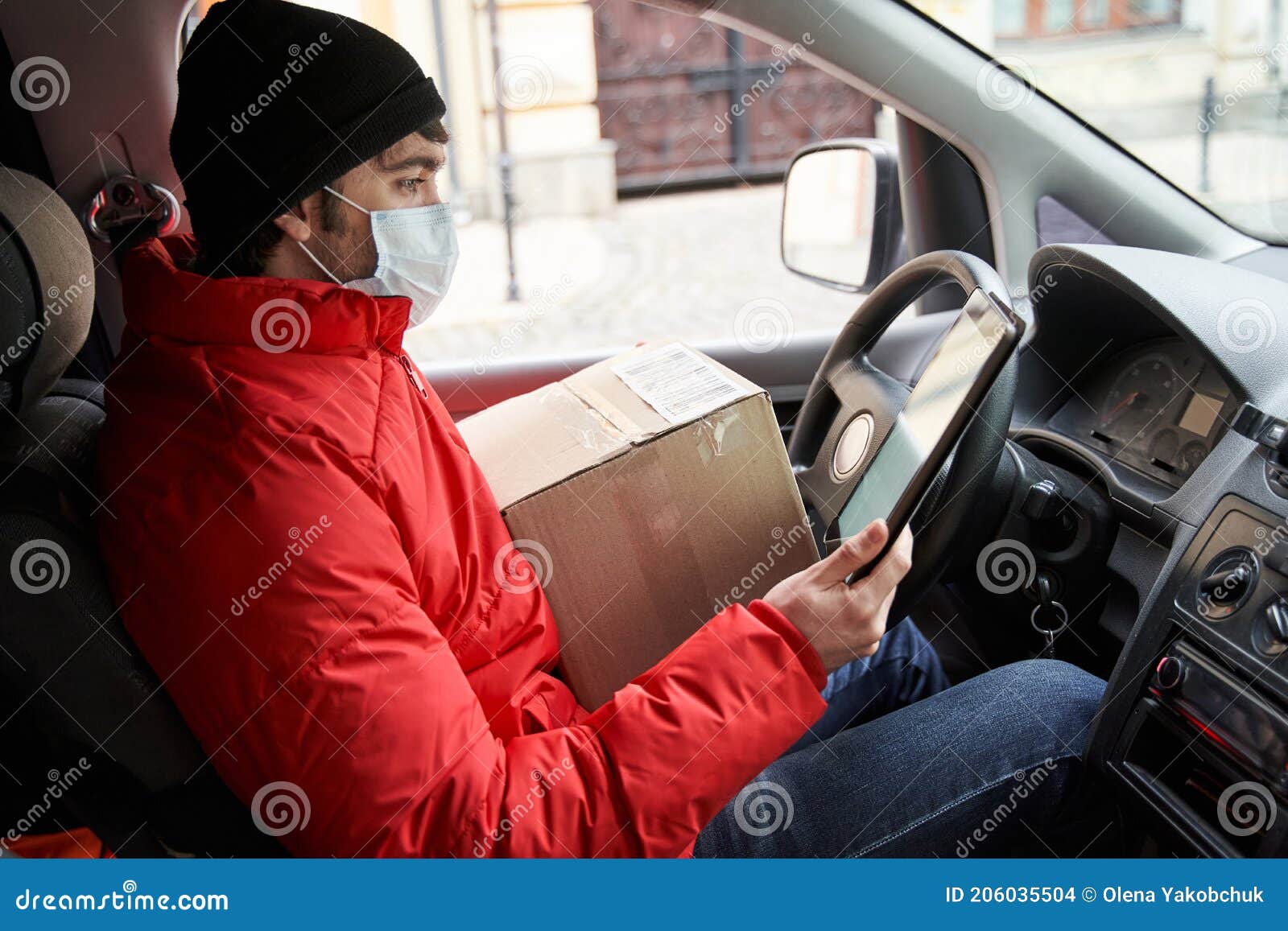 Delivery Driver Checking Something at the Tablet while Sitting at the ...