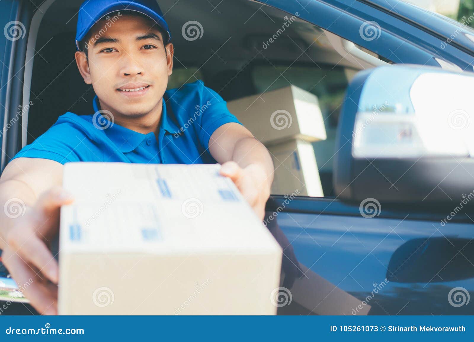 Delivery Driver Offering Parcel To Customer. Stock Image - Image of ...