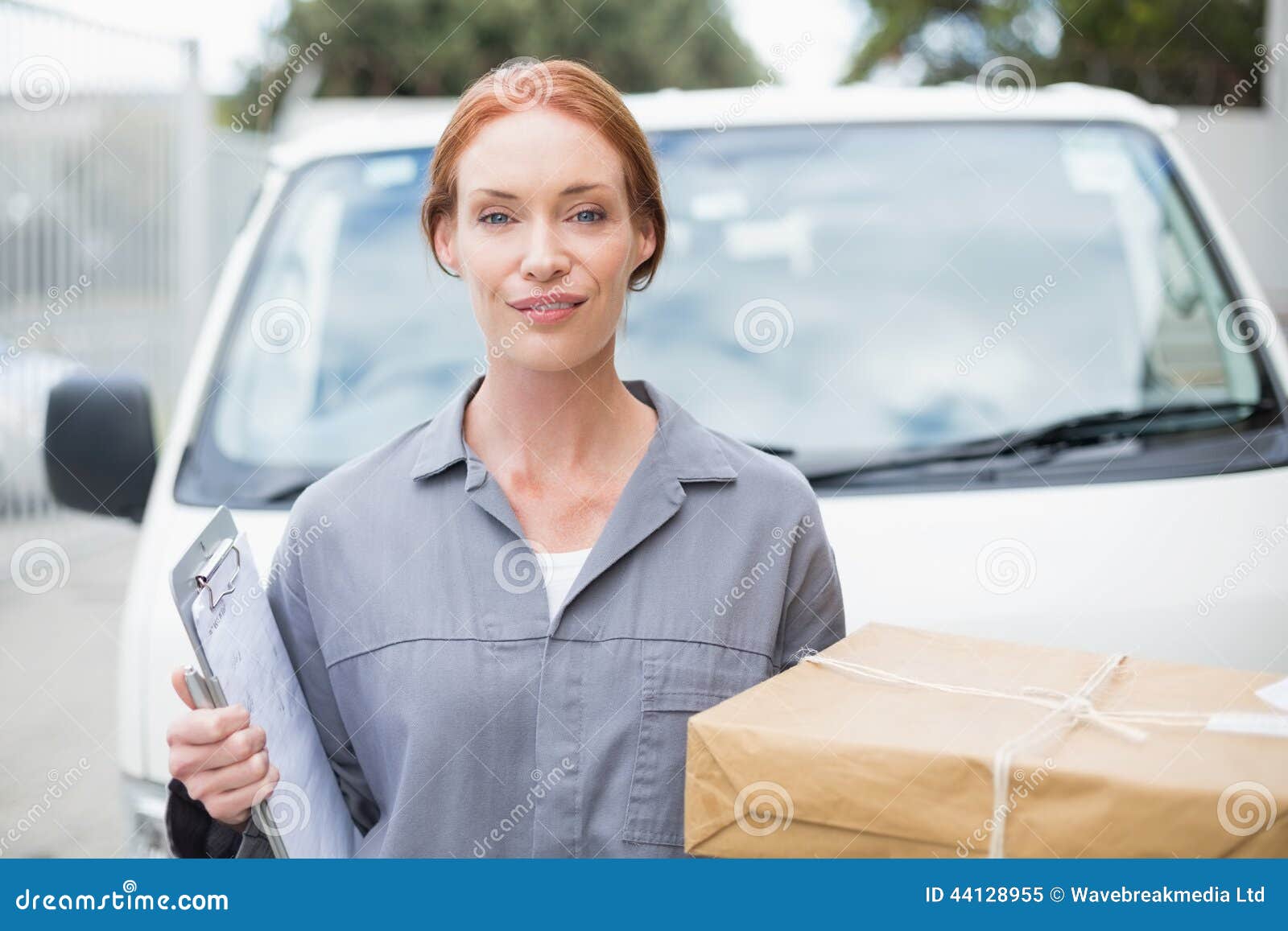 Delivery Driver Smiling at Camera by Her Van Holding Parcel Stock Image ...
