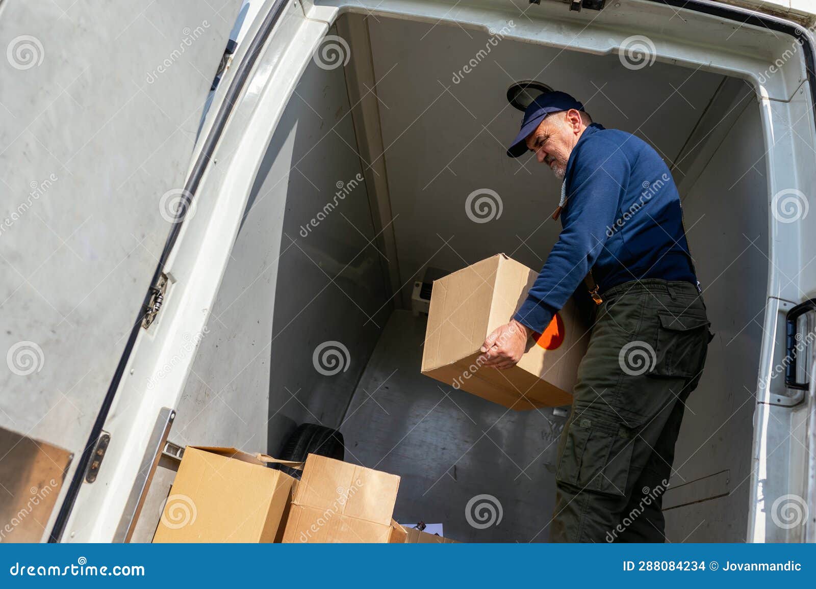 Delivery Man is Taking Out Some Boxes that he Has Been Transporting ...