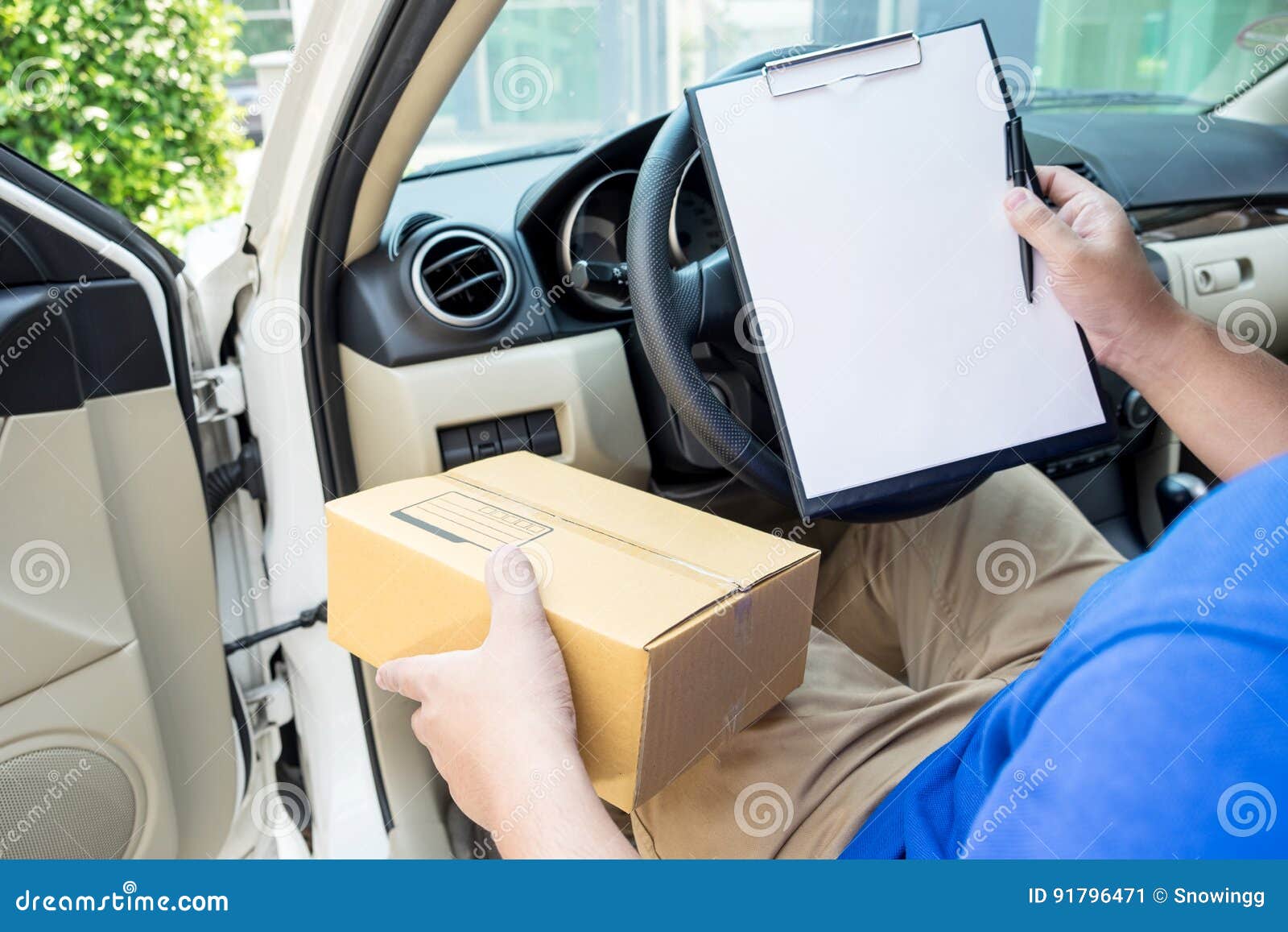 Delivery Man with Cardboard Box Checking Document List in Van an Stock ...