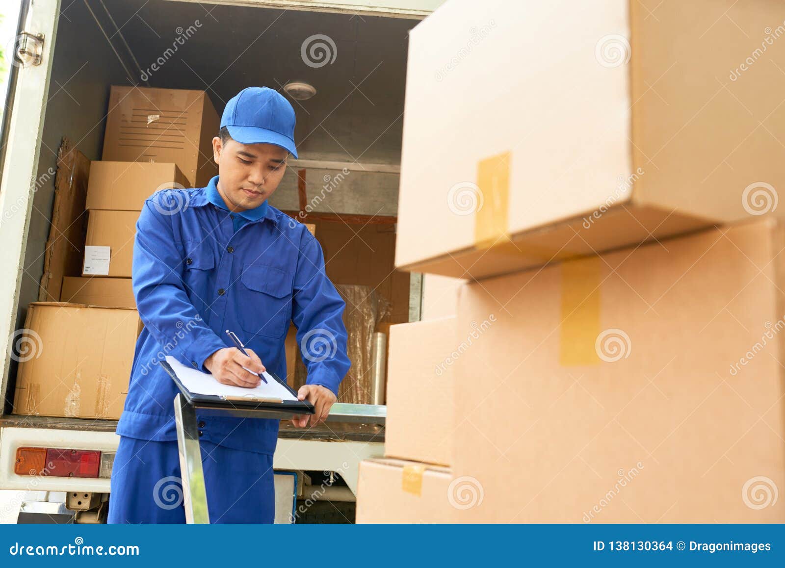 Delivery man loading truck stock photo. Image of service - 138130364