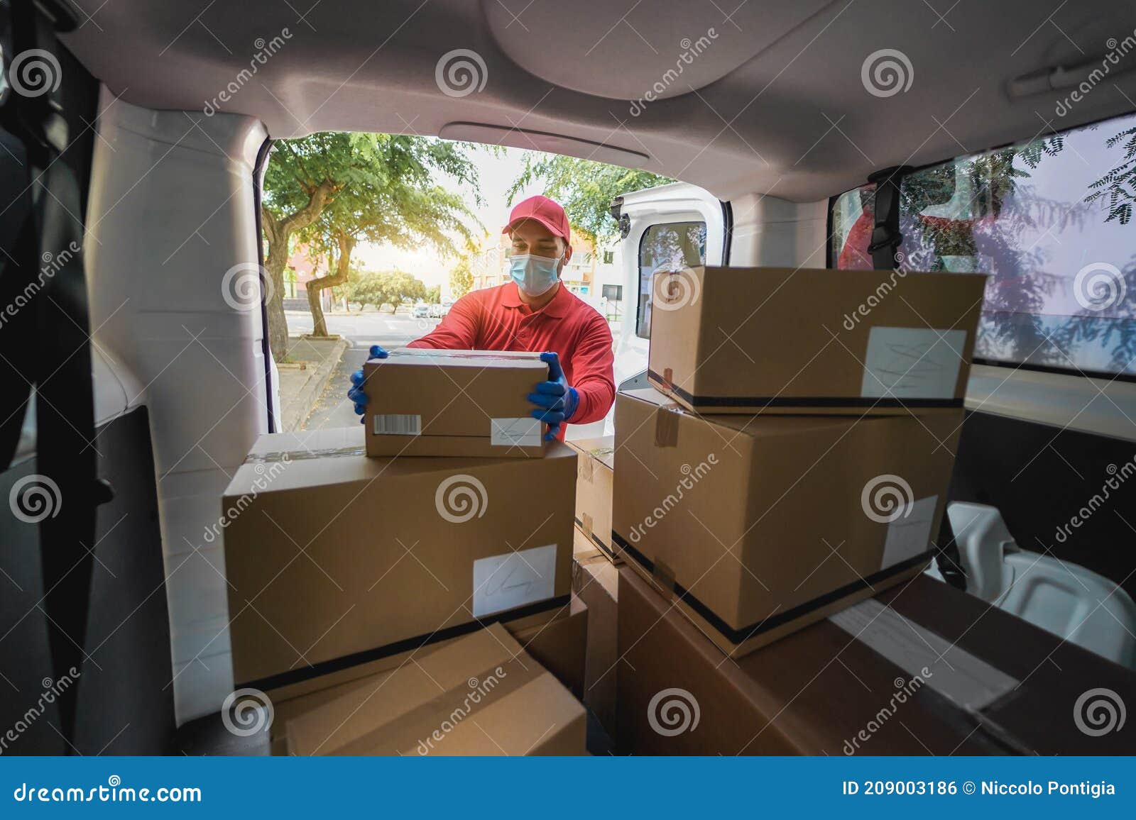 Delivery Man Picking Up Cardboard Box from Van during Coronavirus ...