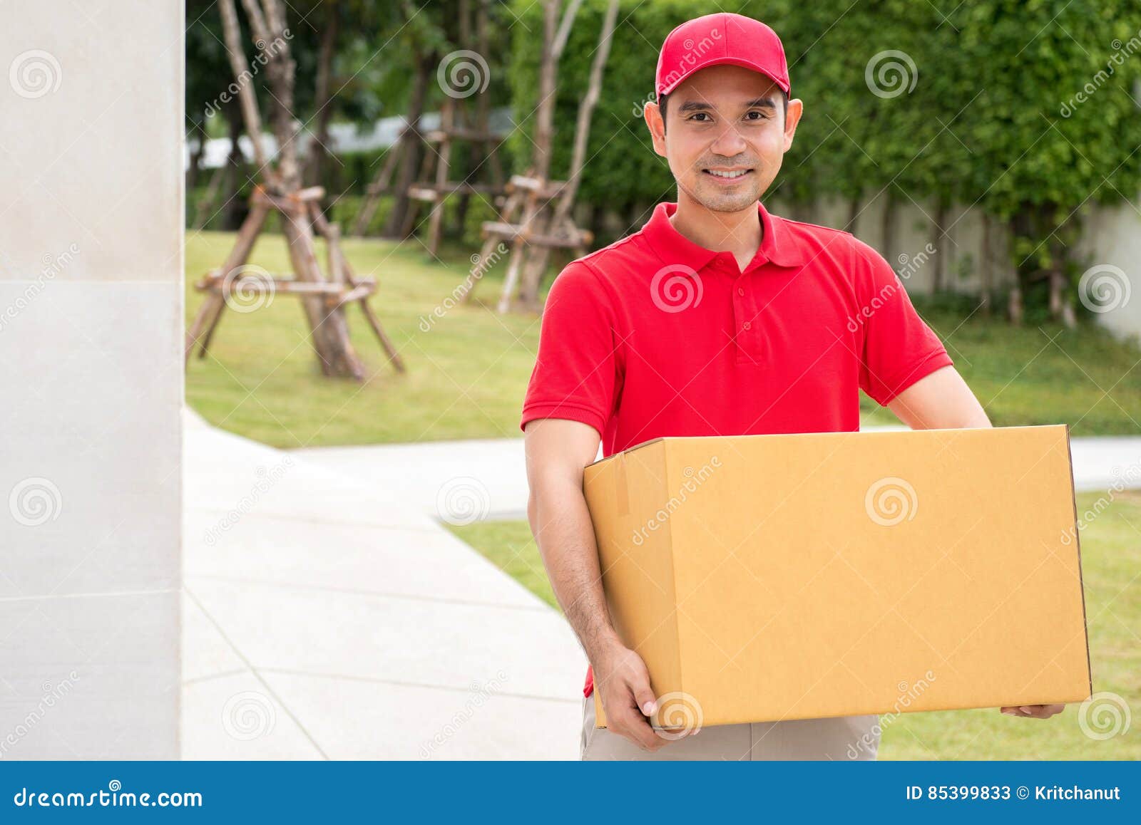 Delivery Man in Red Uniform Holding Box Stock Image - Image of courier ...