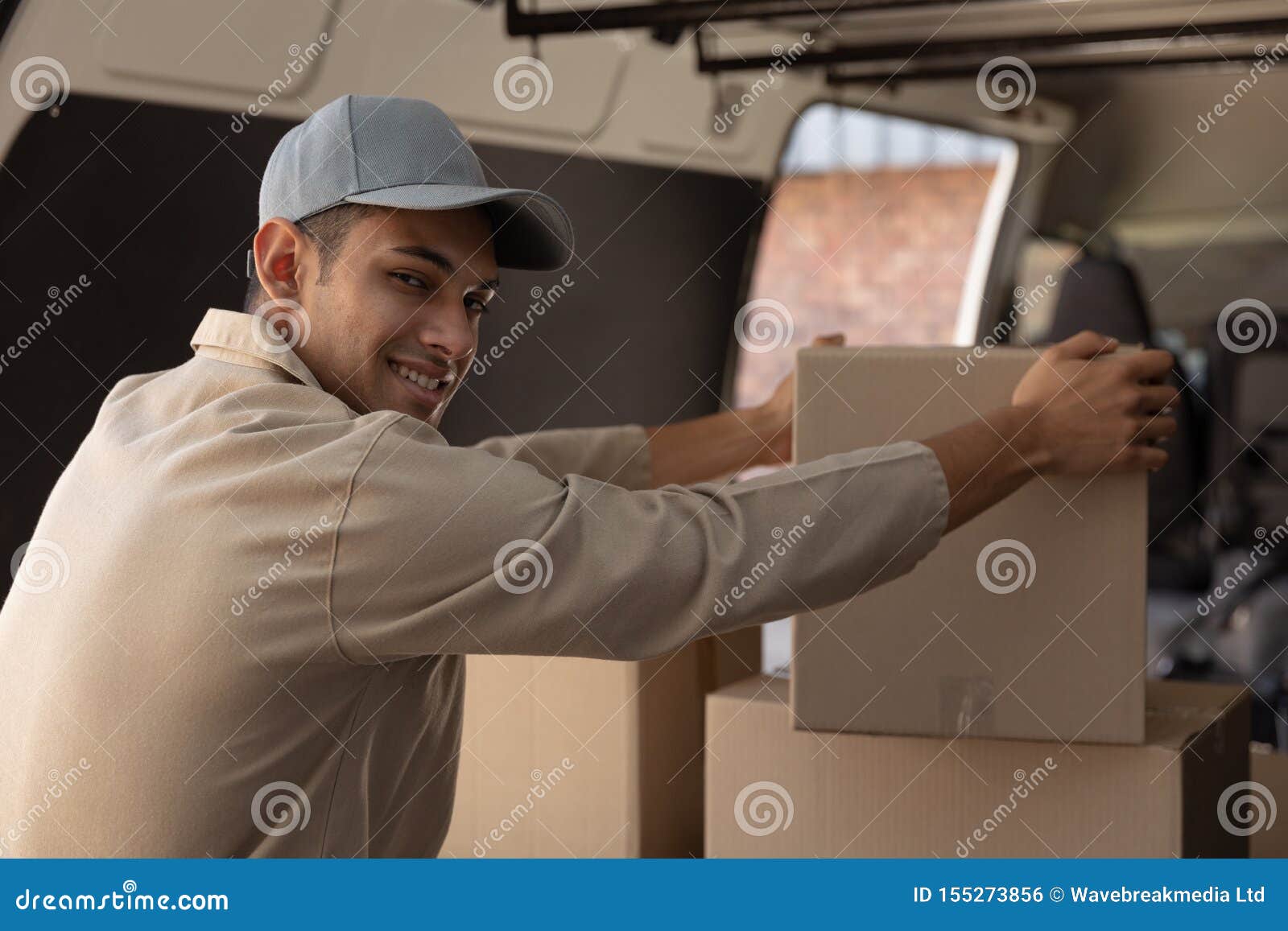Delivery Man Unloading Cardboard Boxes from a Van Outside the Warehouse ...
