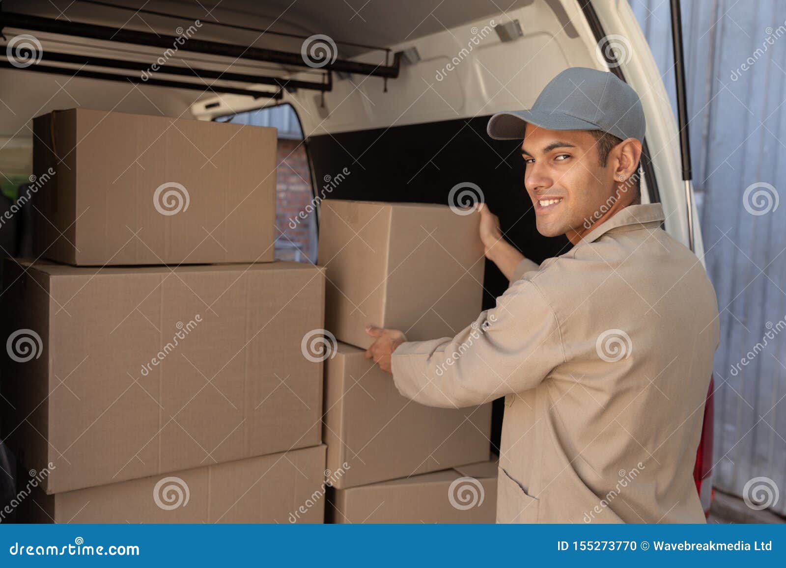Delivery Man Unloading Cardboard Boxes from a Van Outside the Warehouse ...