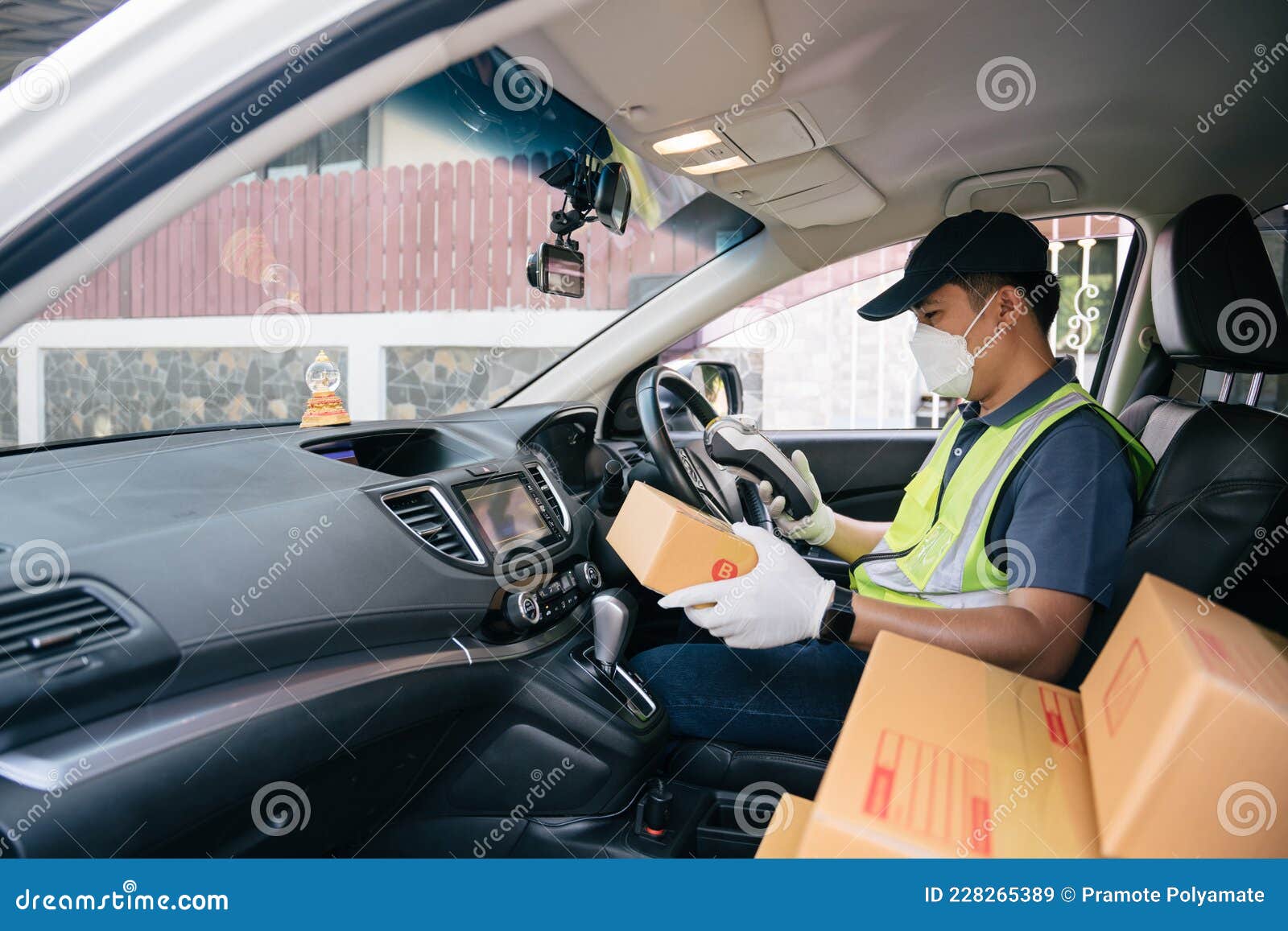 A Delivery Man Using a Credit Card Reader. in the Van with Parcels on ...