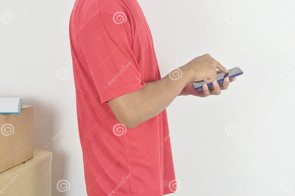 Delivery Man Using Smartphone and Parcel Boxes on the Side Stock Photo ...