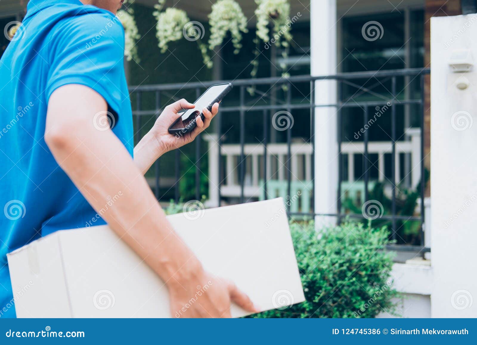 Delivery Service Courier Standing in Front of the House with Box Stock ...