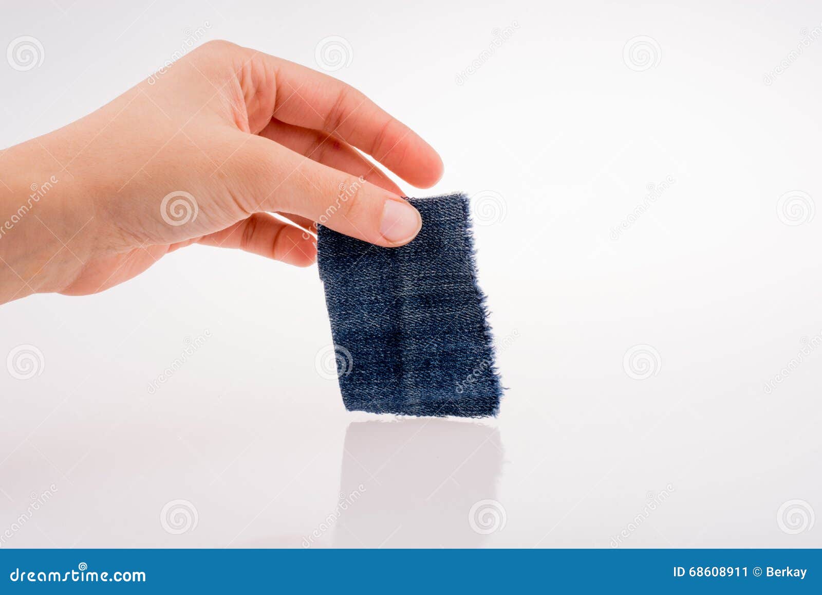 Denim fabric piece in hand stock image. Image of garment - 68608911