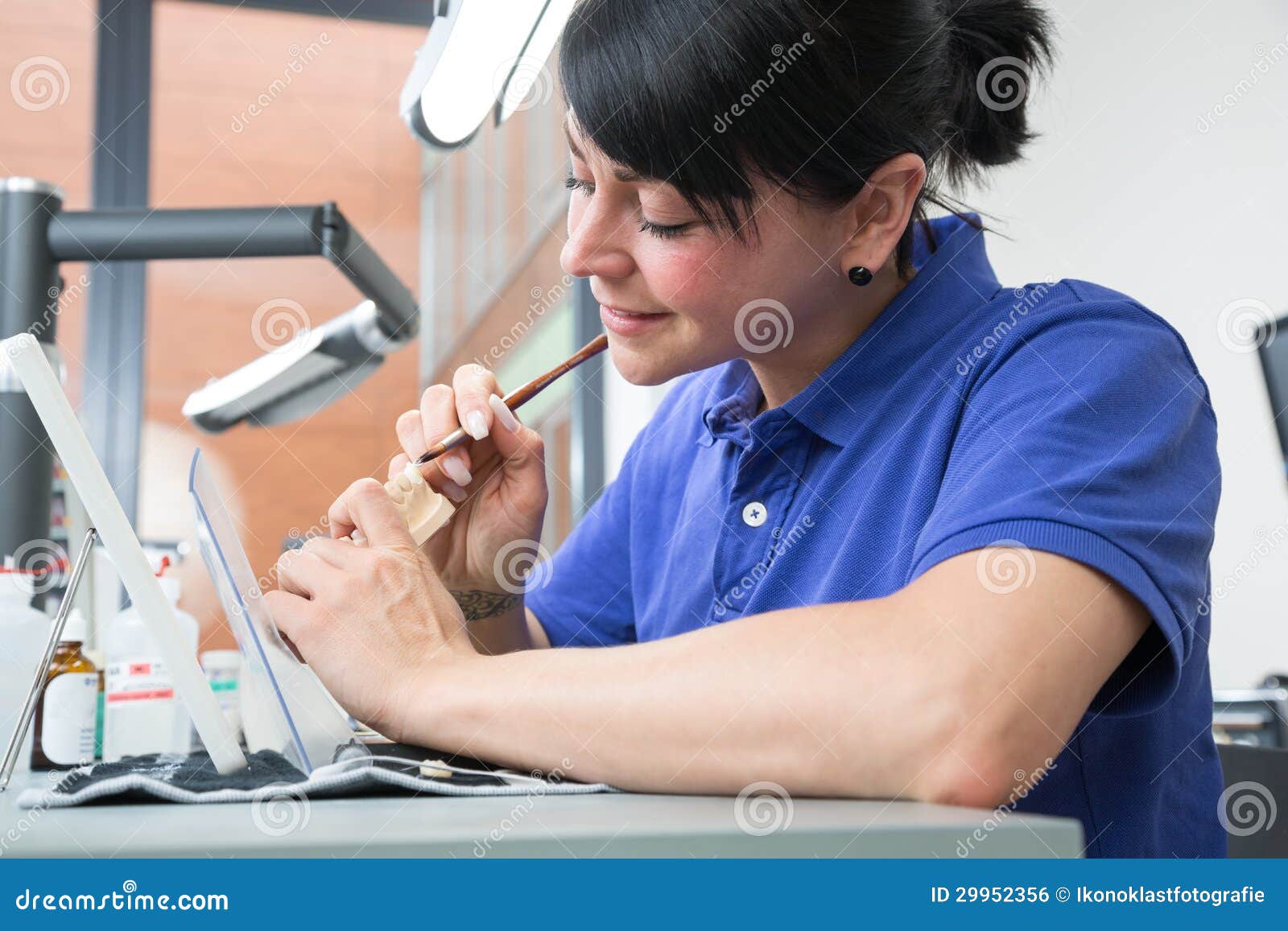 Technician in a Dental Laboratory Applying Ceramics To a Prosthesis ...