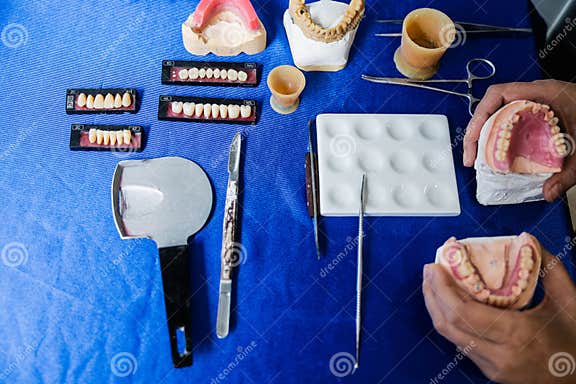 Dental Tools and Prosthetic Teeth Molds on a Blue Workspace Stock Photo ...