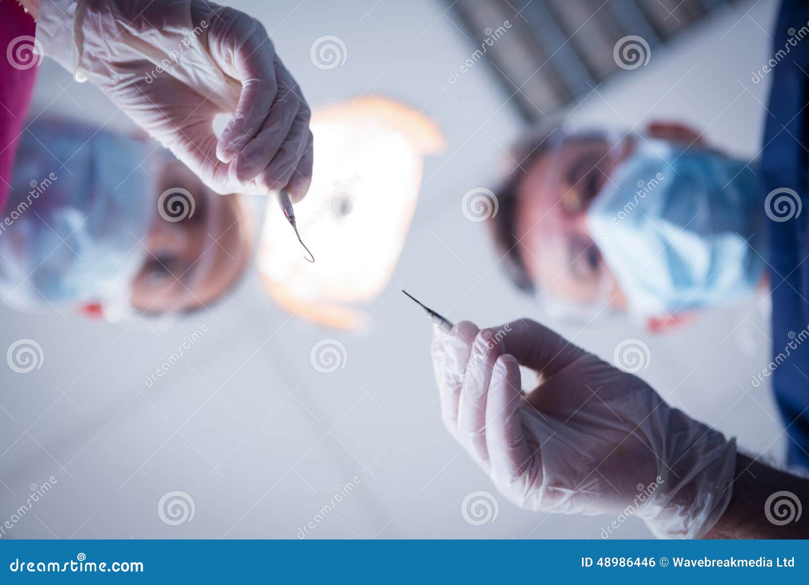 Dentist and Assistant Leaning Over Patient with Tools Stock Photo ...