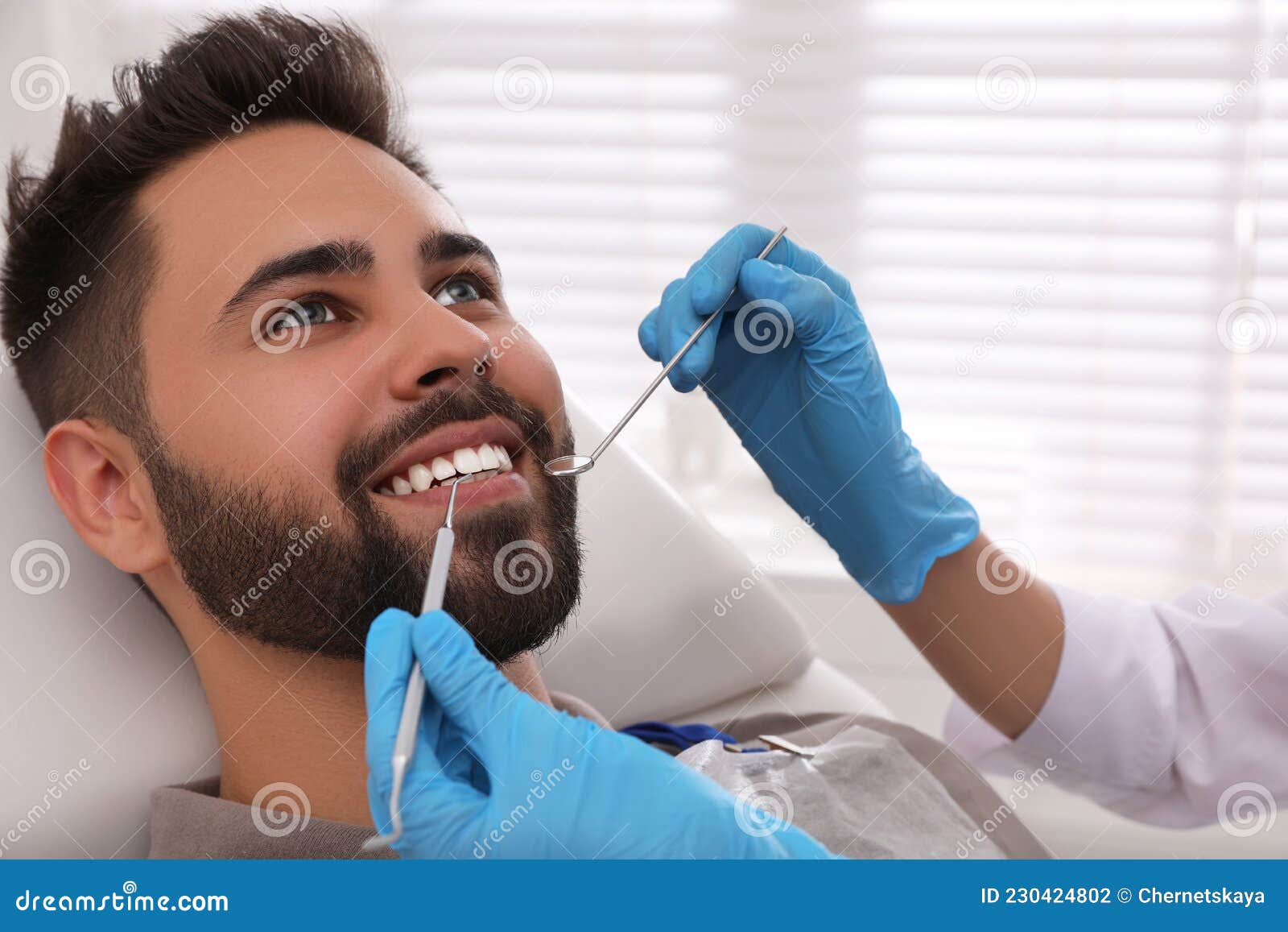 Dentist Examining Young Man`s Teeth in Modern Clinic Stock Photo ...