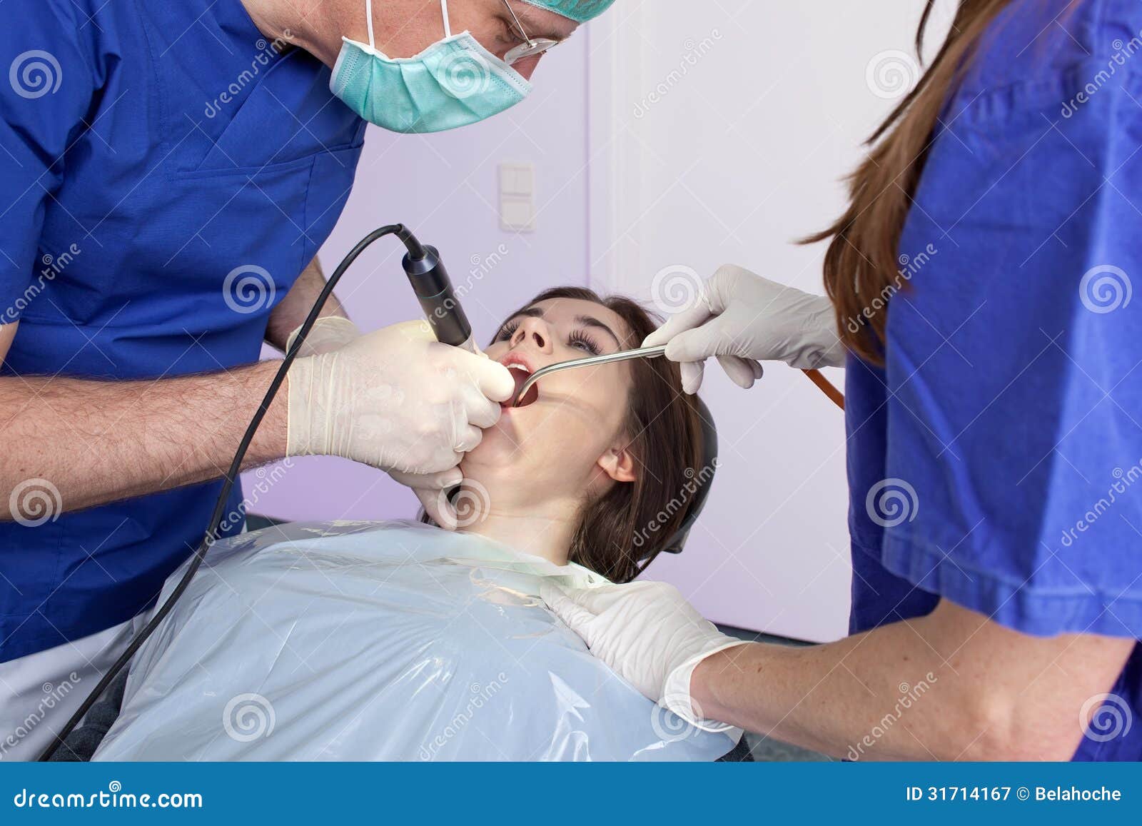 Dentist and His Assistant Operating on a Patient. Stock Image - Image ...