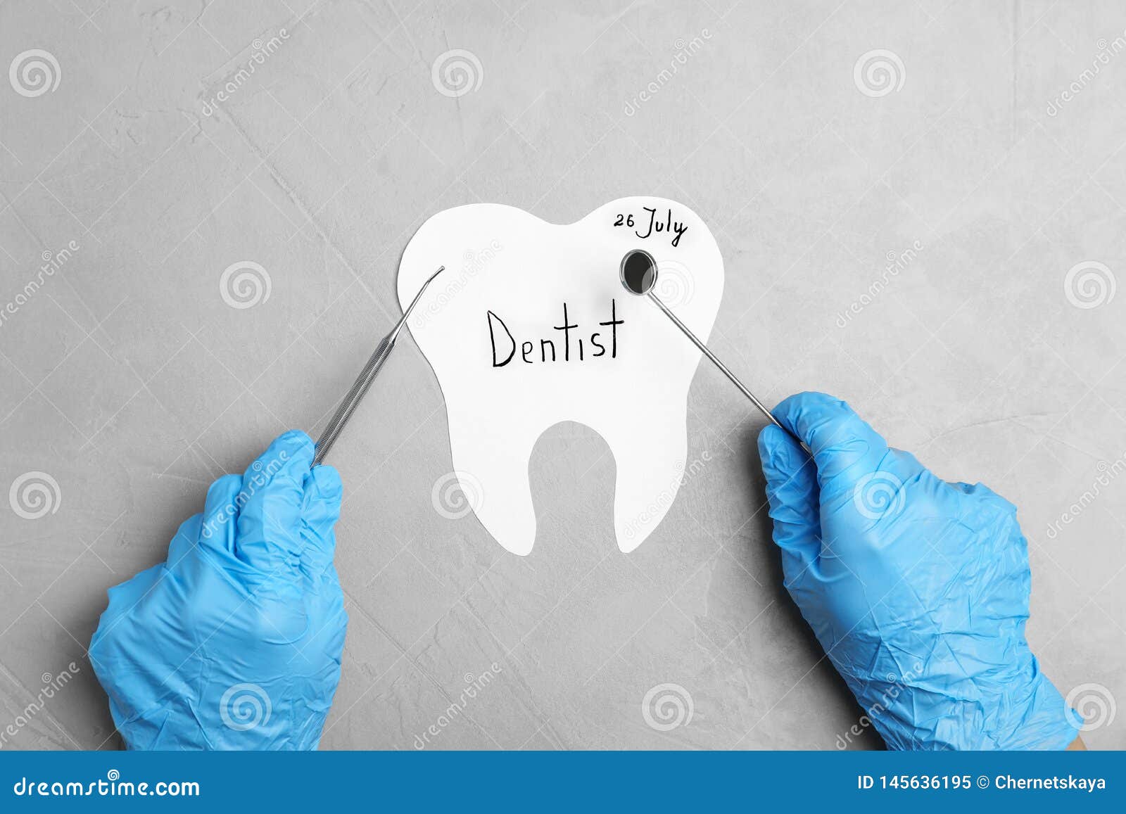 Dentist Holding Professional Tools Over Paper Tooth on Grey, Top View ...