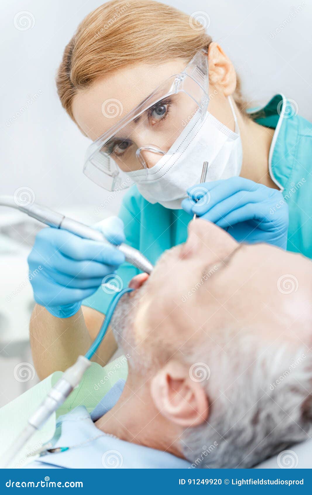 Dentist in Protective Glasses and Mask Curing Mature Patient Stock ...